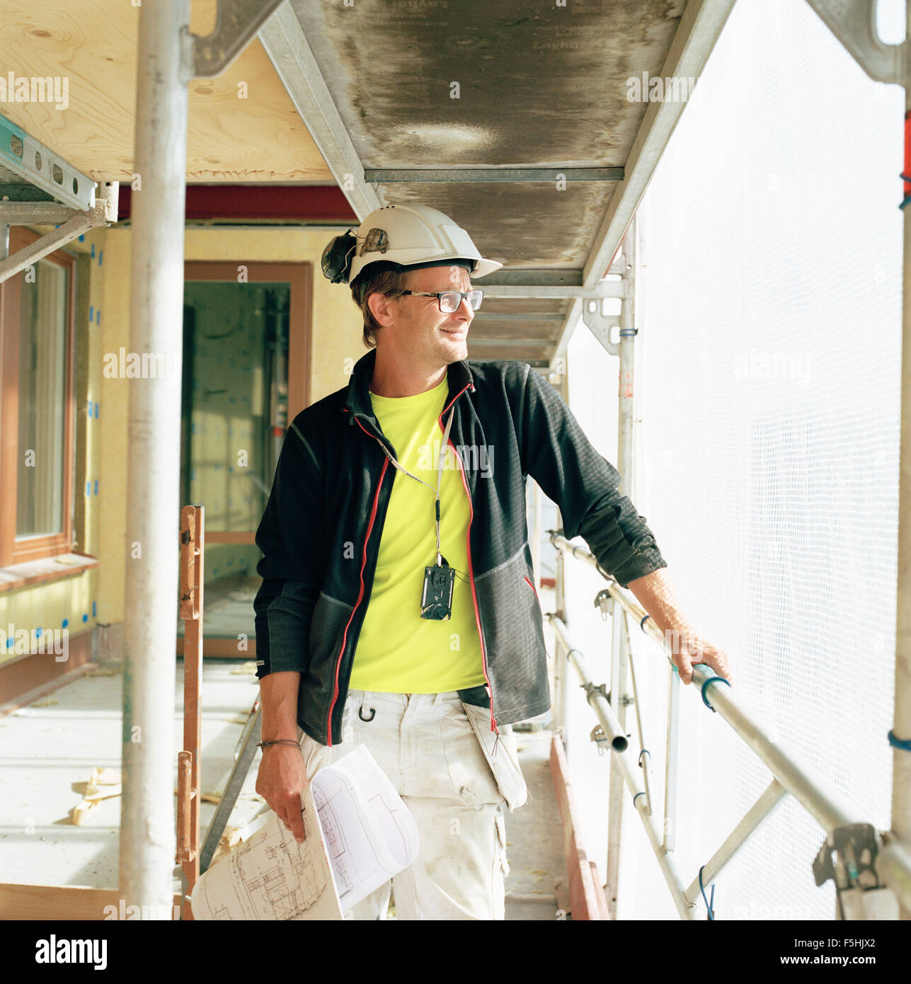 Sweden, Construction worker holding blueprints Stock Photo - Alamy