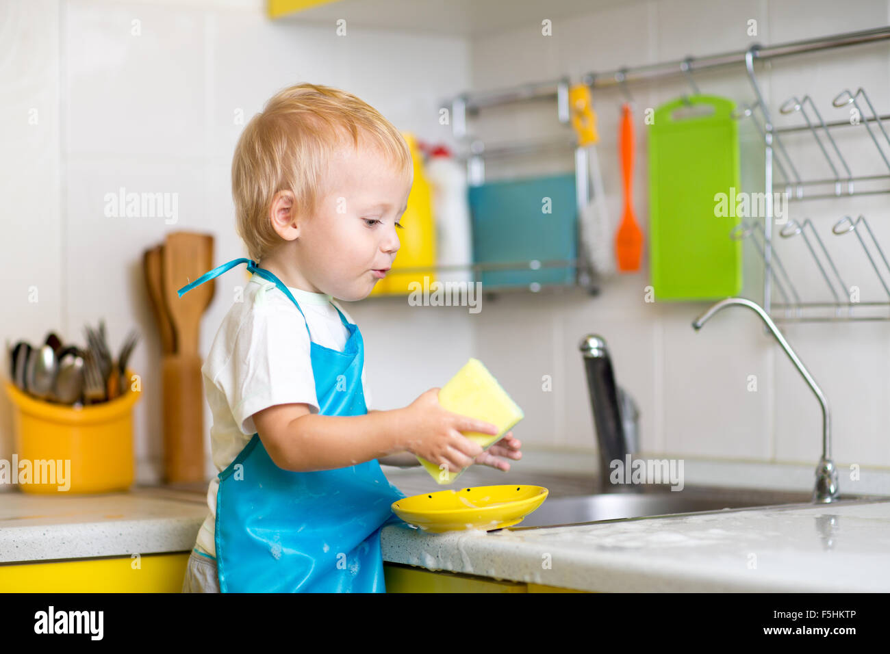 Child boy cleaning the kitchen after dinner Stock Photo - Alamy