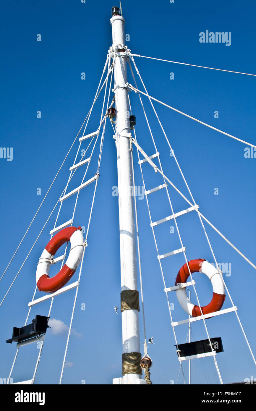 Sailing mast with life buoy over blue sky Stock Photo - Alamy
