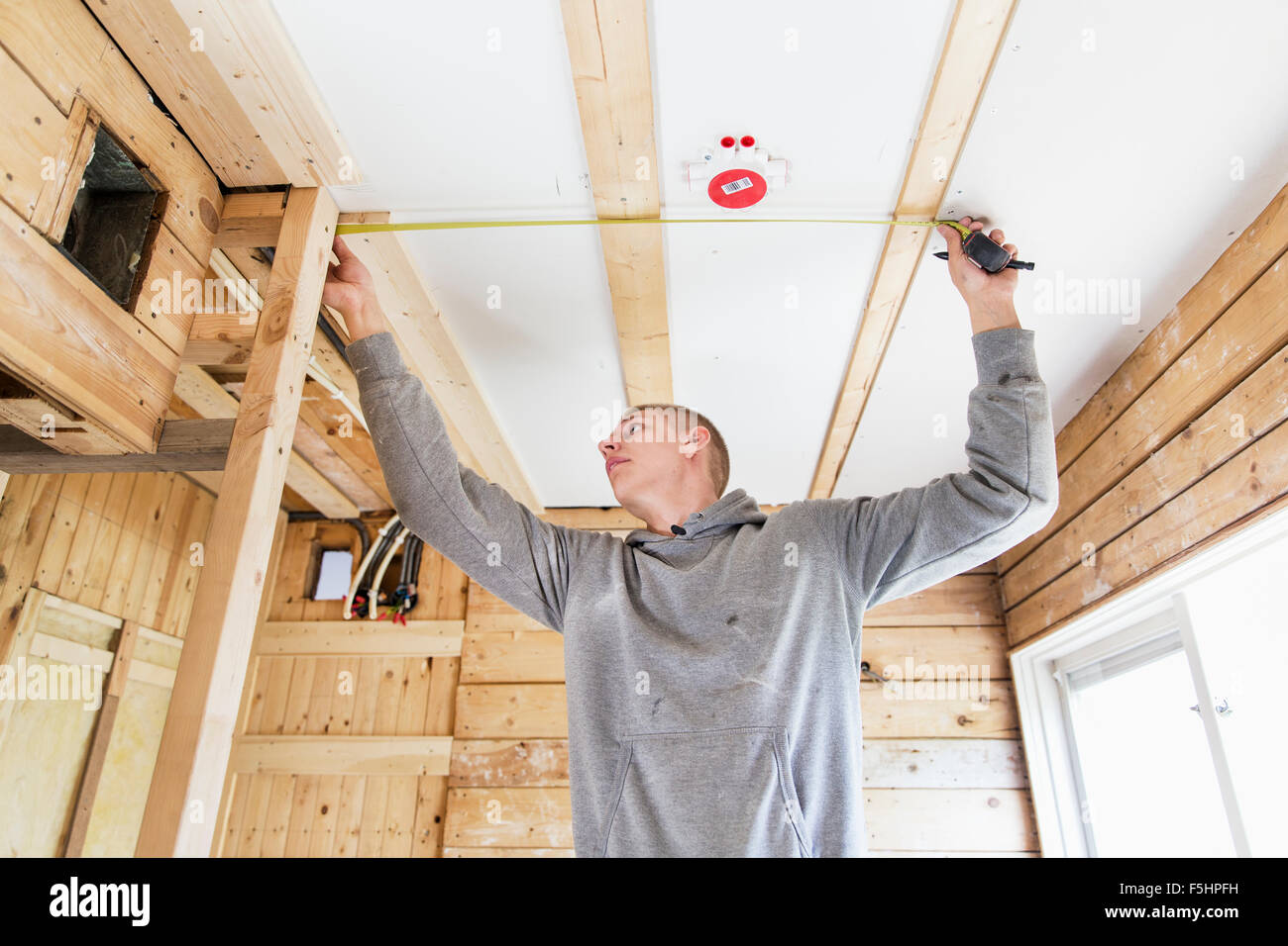 Sweden, Man measuring ceiling Stock Photo - Alamy