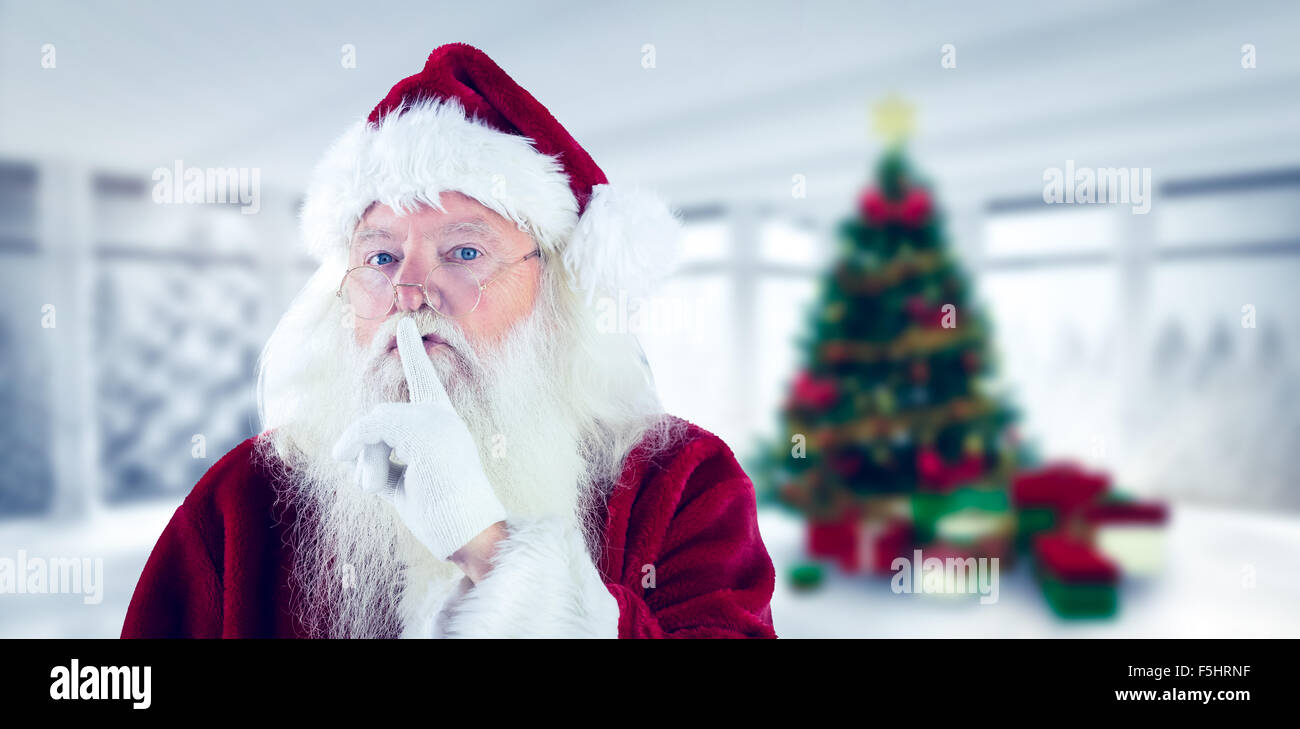 Composite image of santa asking for quiet to camera Stock Photo - Alamy