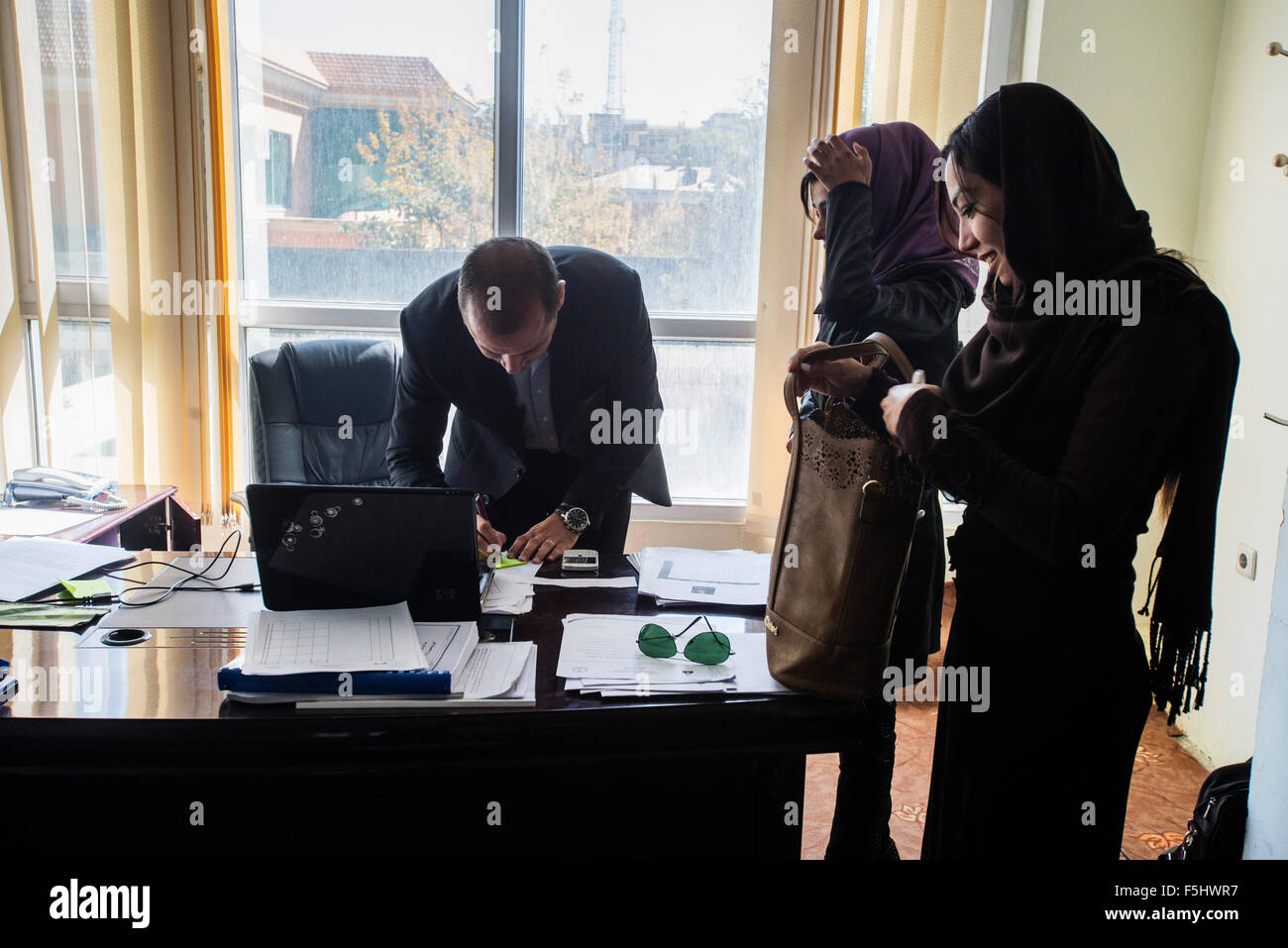 Two female students stand in cabinet of their teacher Haroon Hakimi in ...