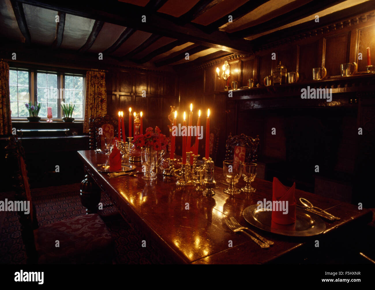 Glassware and lighted candles on table in Tudor style dining room Stock ...