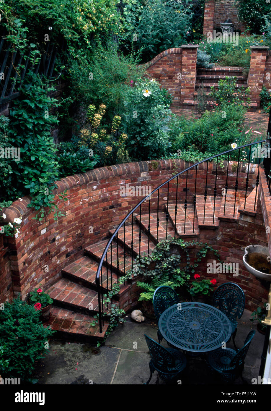 Birds-eye view of black metal table and chairs on a sunken patio beside ...