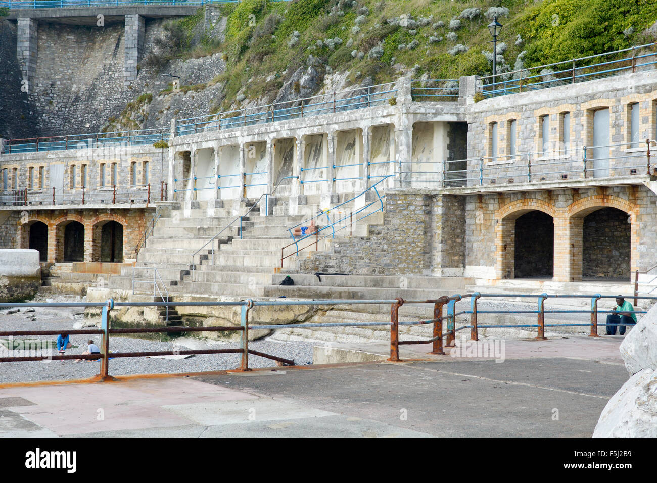 People relaxing and sunbathing on the steps of the old Victorian ...