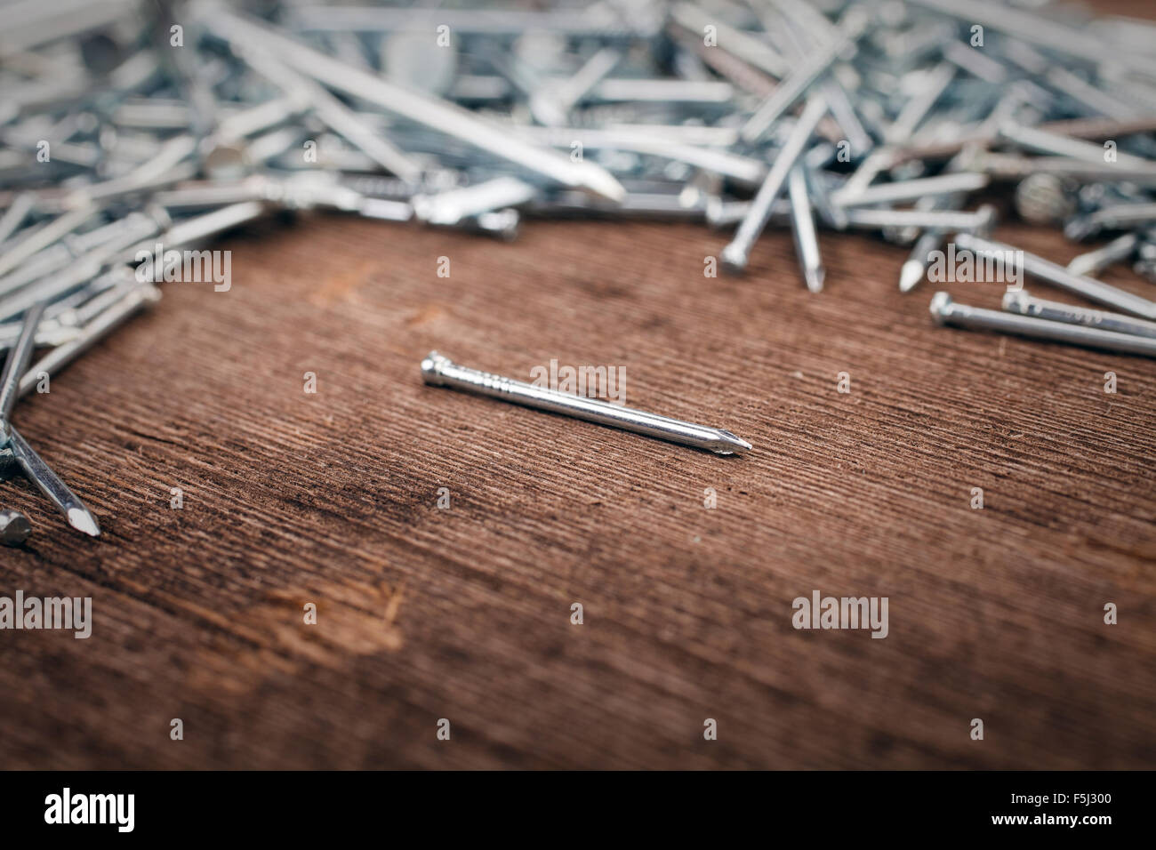 iron nails on wooden background Stock Photo - Alamy