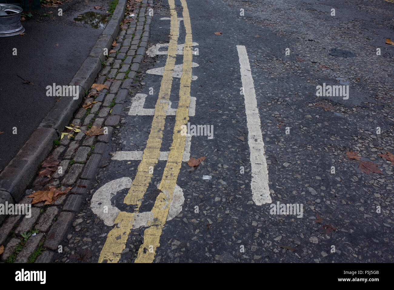 Double-yellow lines painted over lettering stating a clearway to a ...