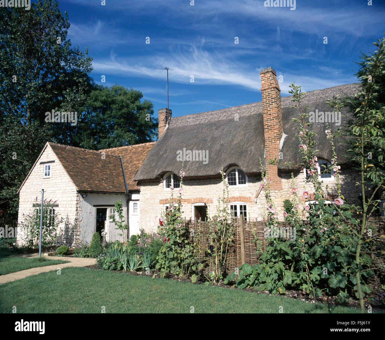 Exterior of a traditional thatched country cottage with small extension ...