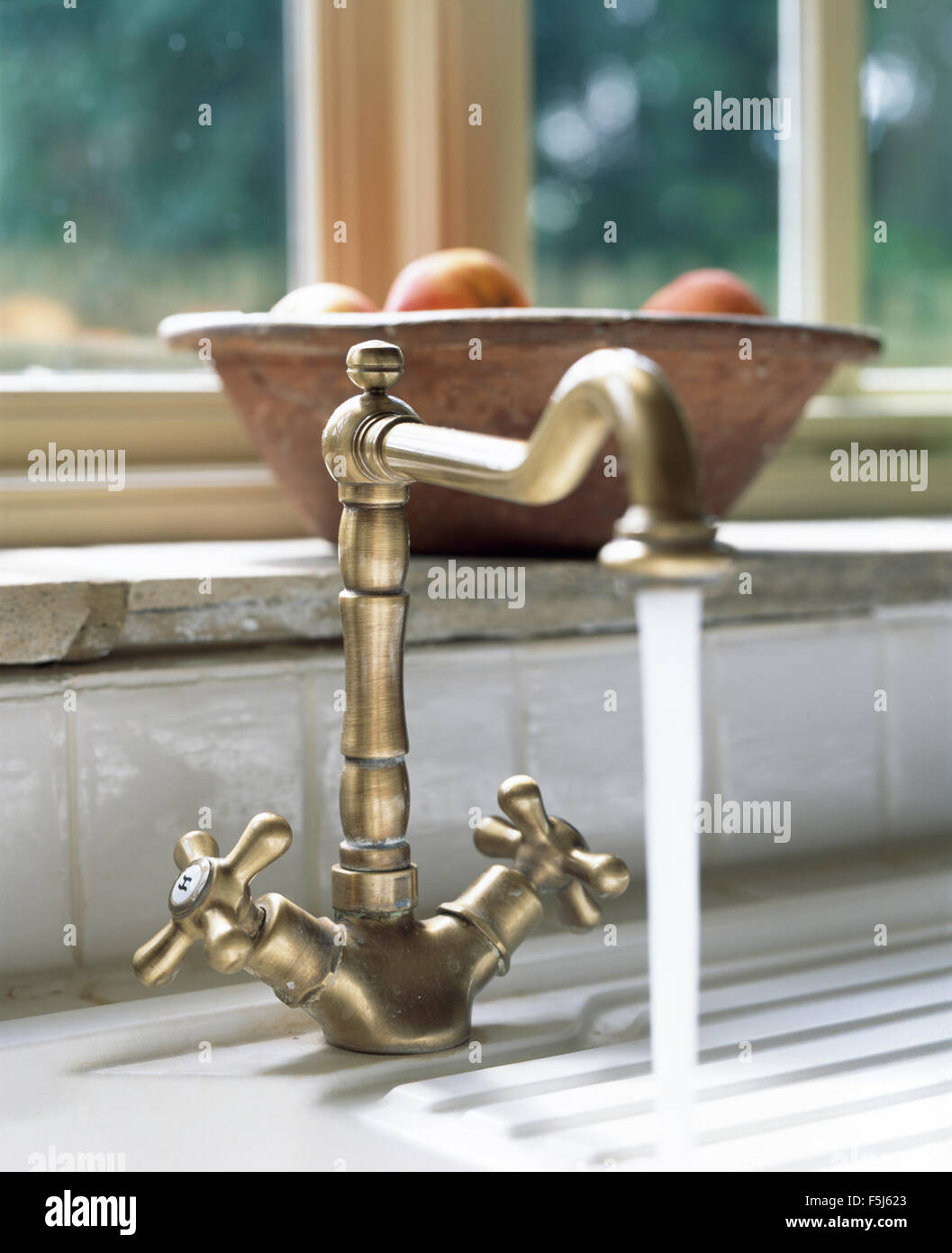 Close-up of a brass mixer tap pouring water into the sink Stock Photo ...