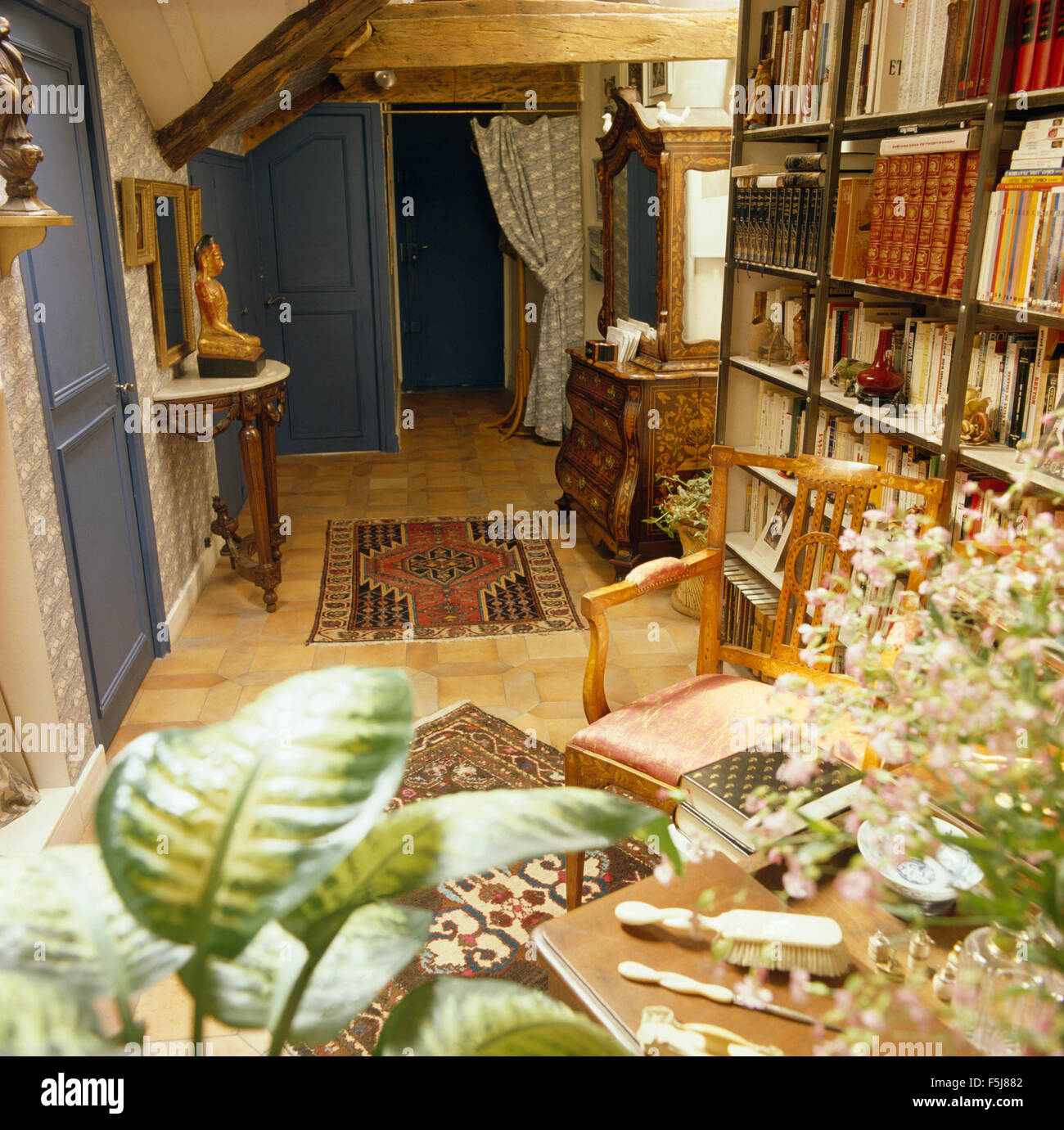 Fitted bookcase and Persian rugs in hall of an early eighties loft ...