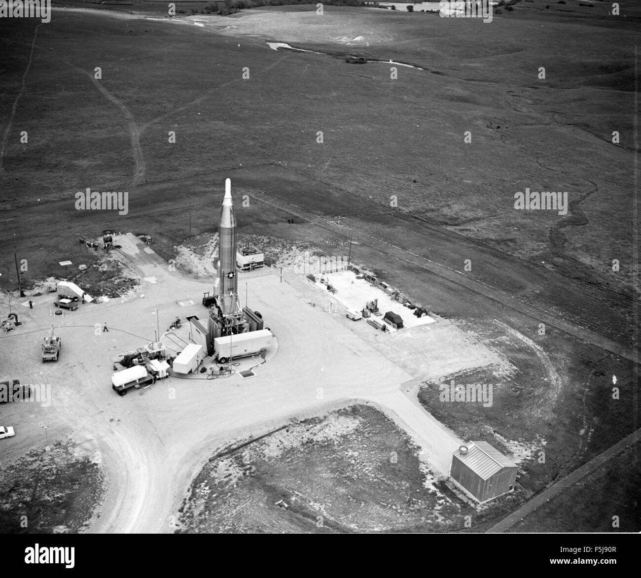 An aerial view of Schilling AFB, showing an Atlas missile being erected ...