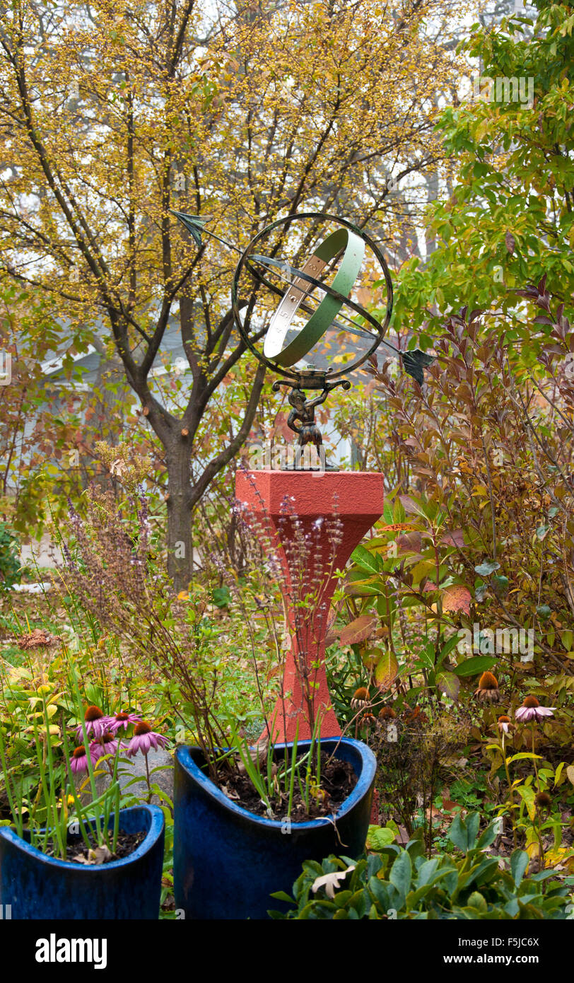Sundial and blue ceramic planting container in a fall garden Stock ...