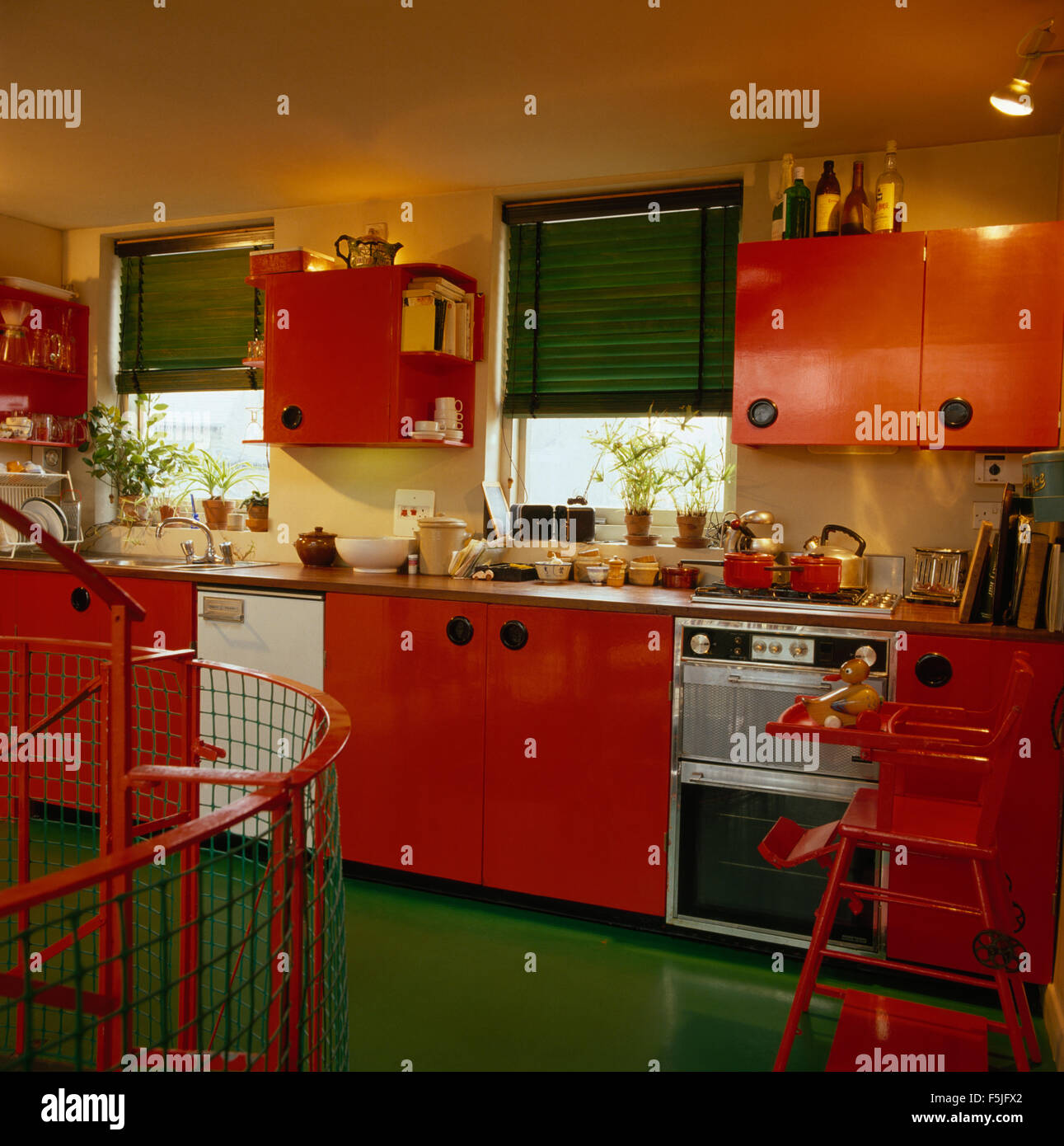 Green blinds and flooring in a seventies kitchen with bright red doors ...