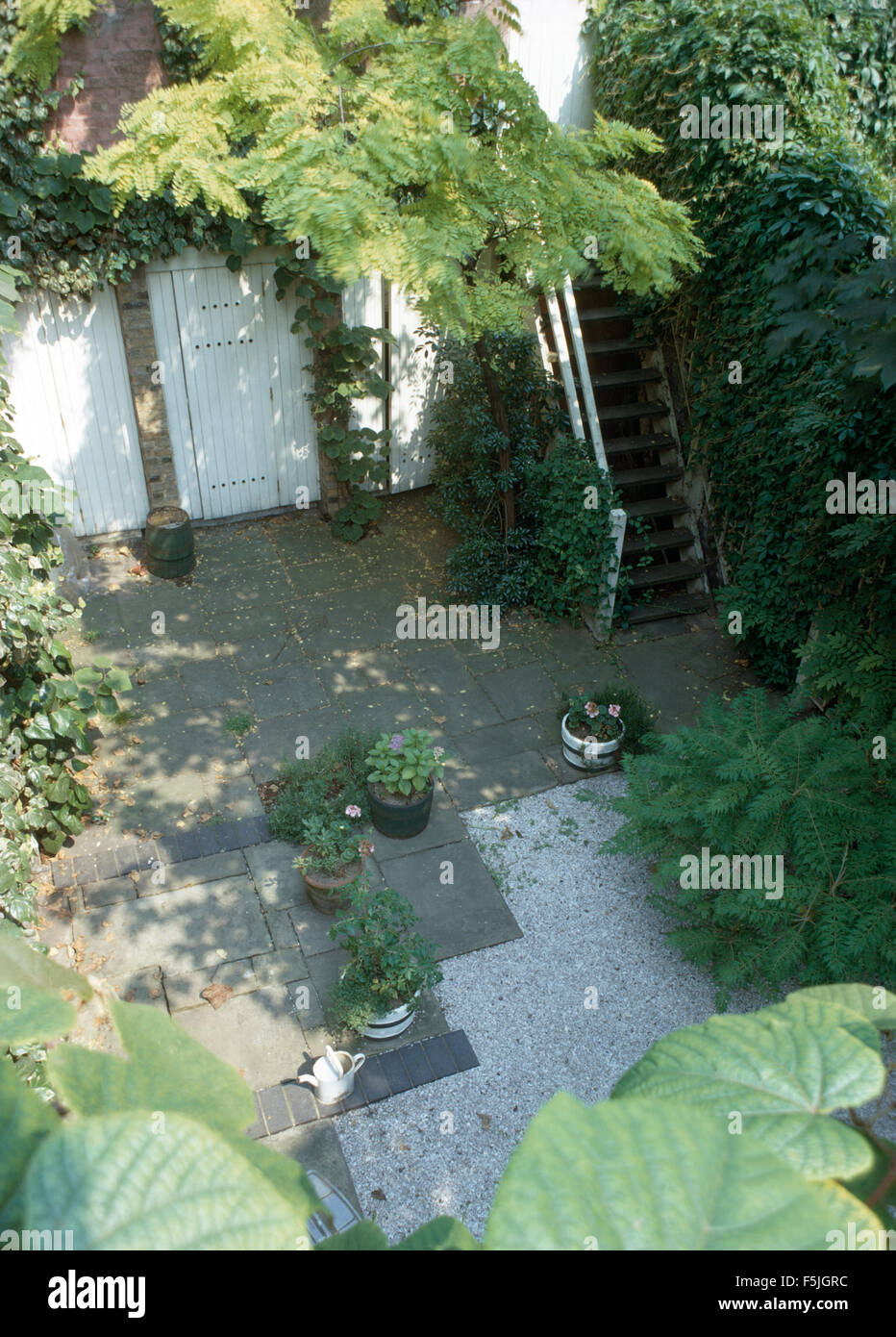 Birds-eye view of a small paved courtyard with a flight of wooden steps ...