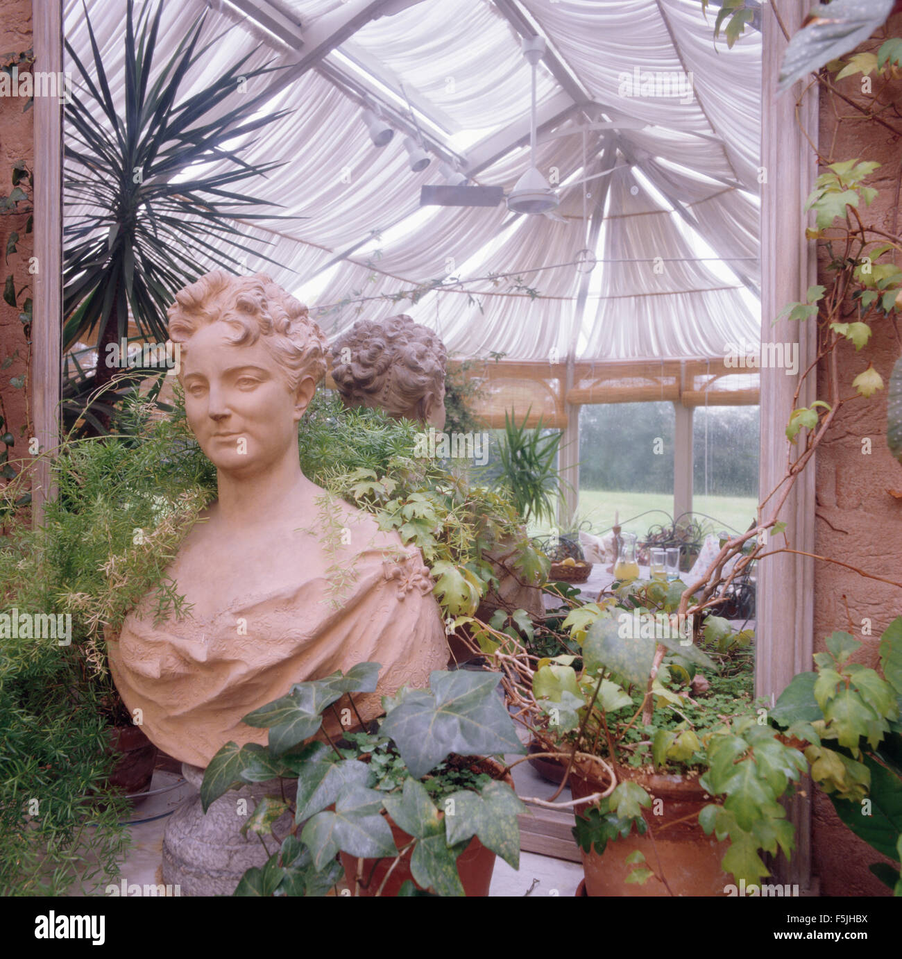 Terracotta bust in an eighties conservatory with white blinds on glass ...