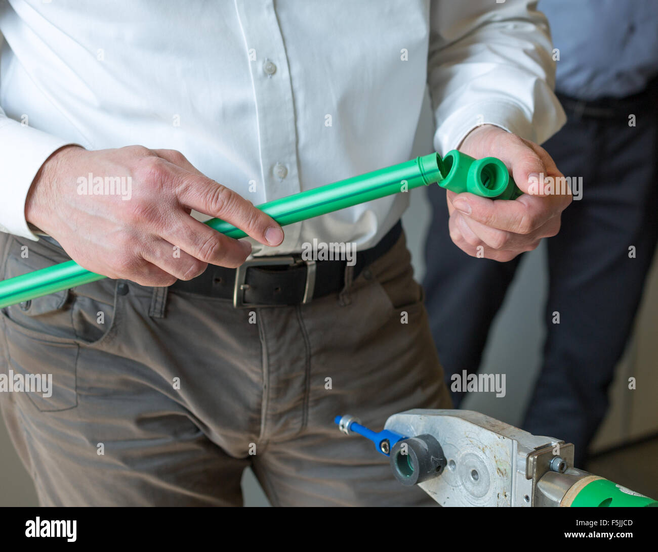 Mechanic working with pipes at workroom Stock Photo - Alamy