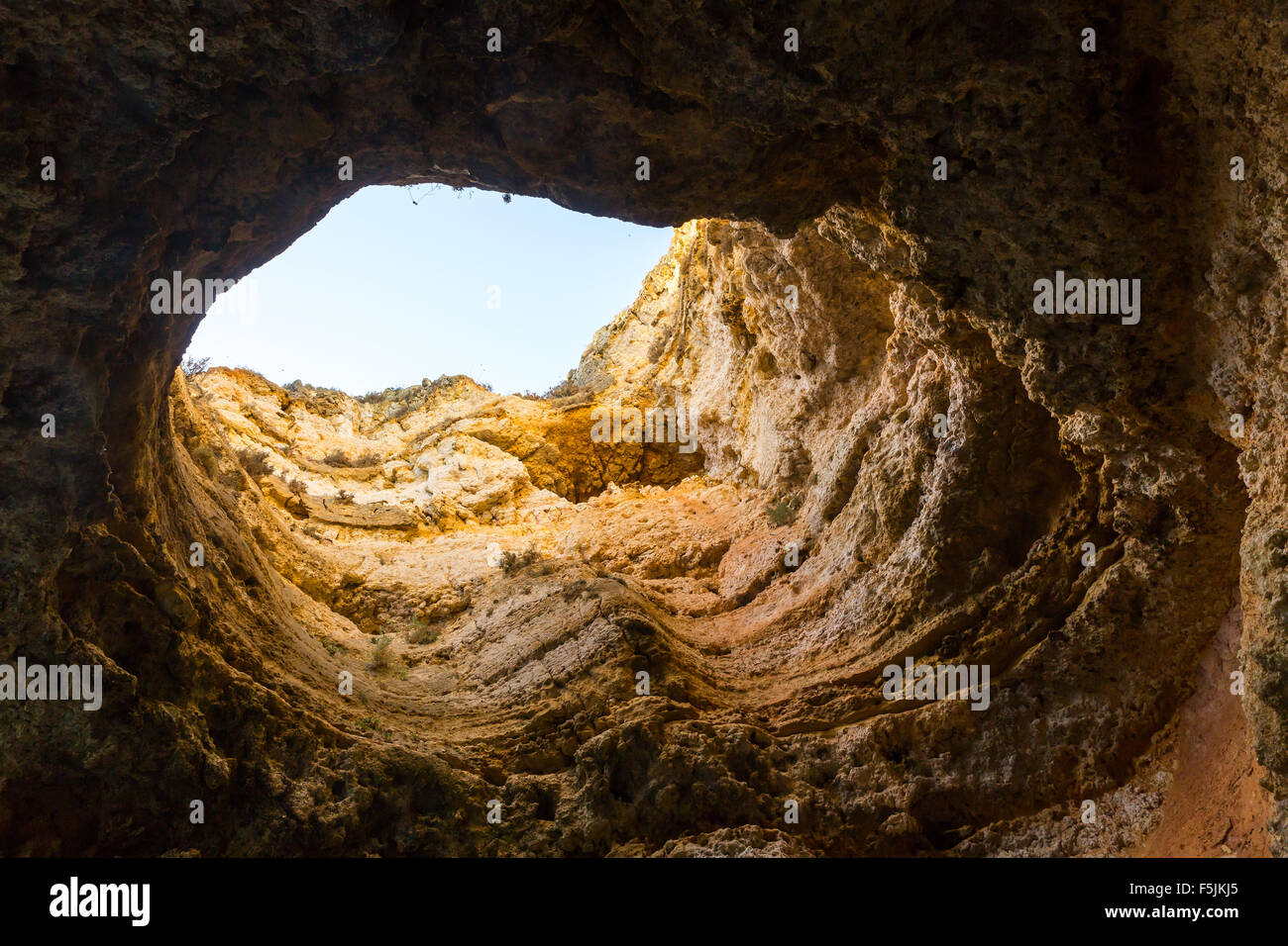 Light in the end of round rocky cave Stock Photo - Alamy