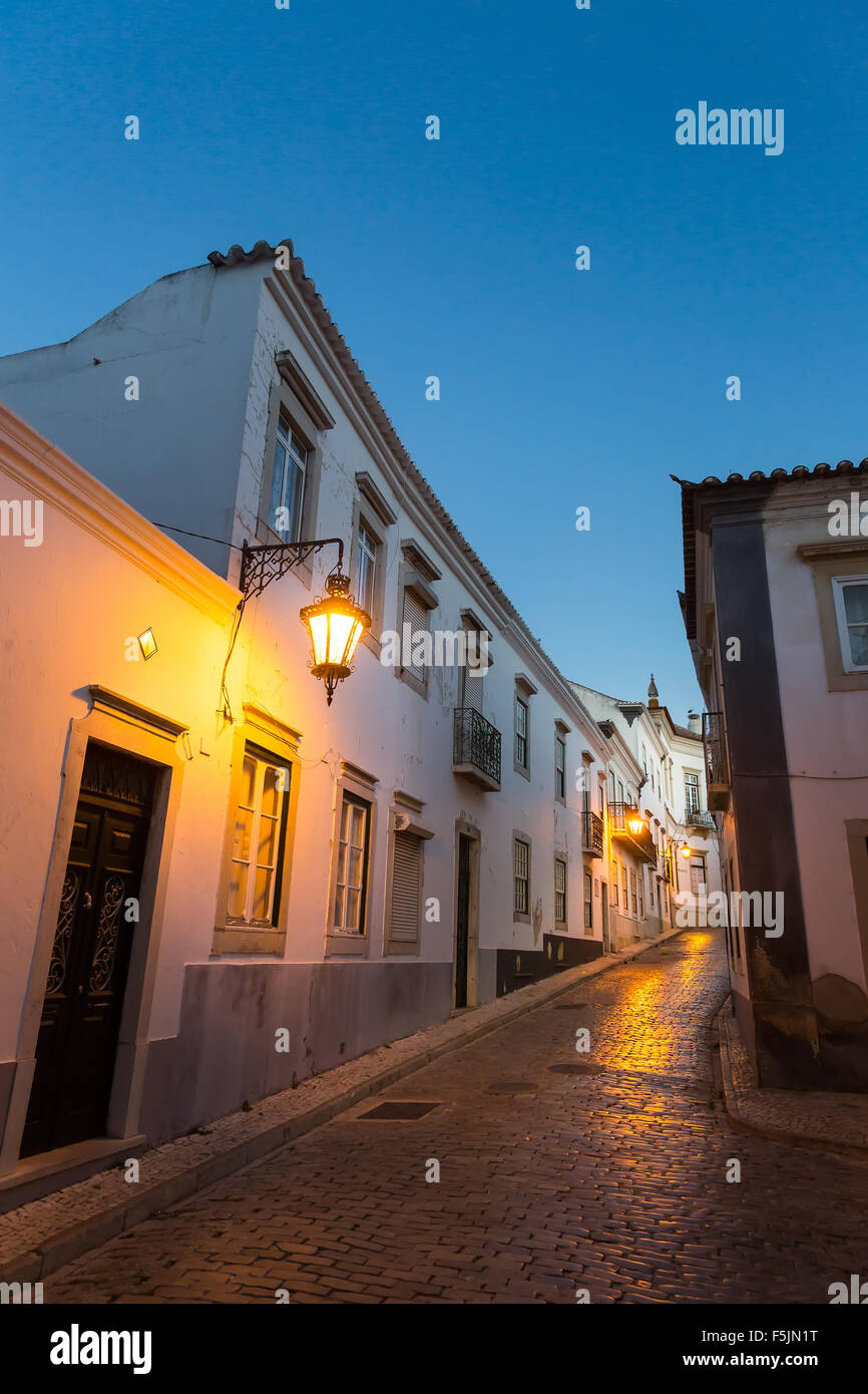 Narrow european street with paved road in the evening Stock Photo - Alamy