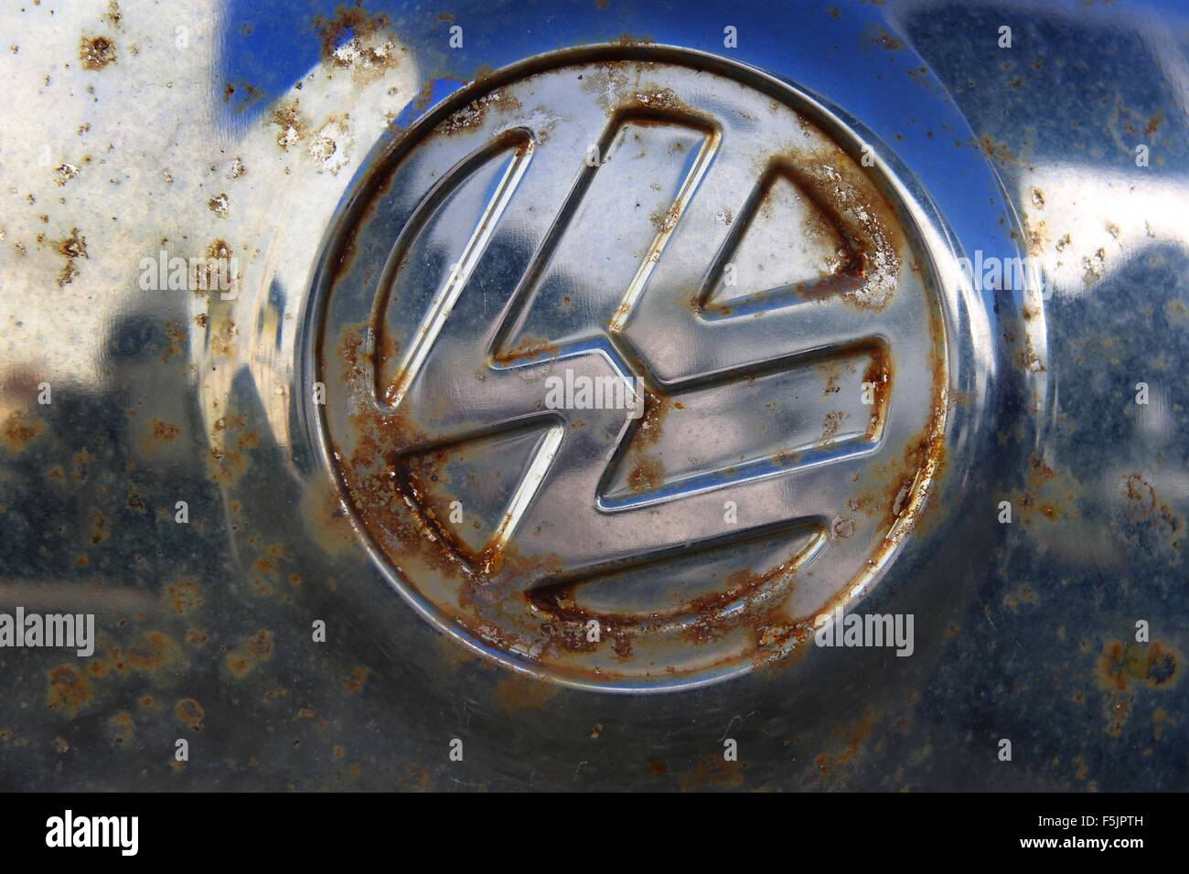 A rusty VW Logo on the hubcap of an old VW Beetle at a garage in ...
