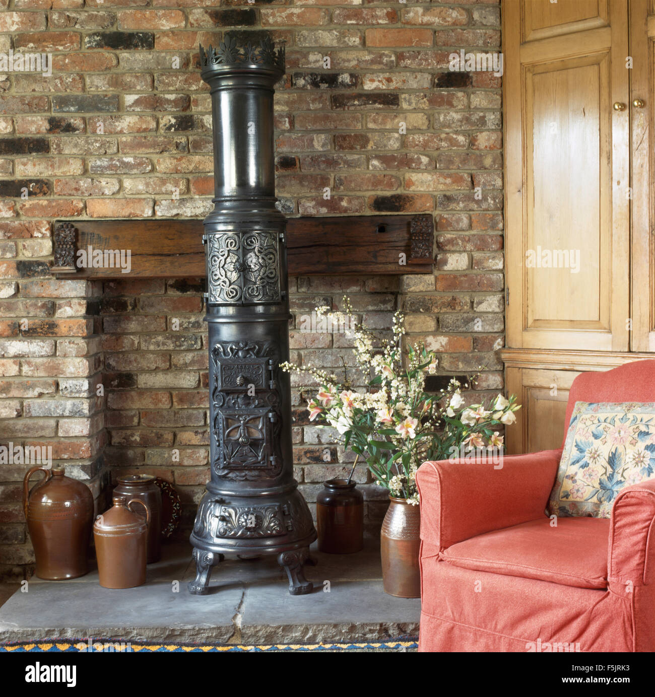 Tall cast iron Victorian stove in cottage living room with pink ...