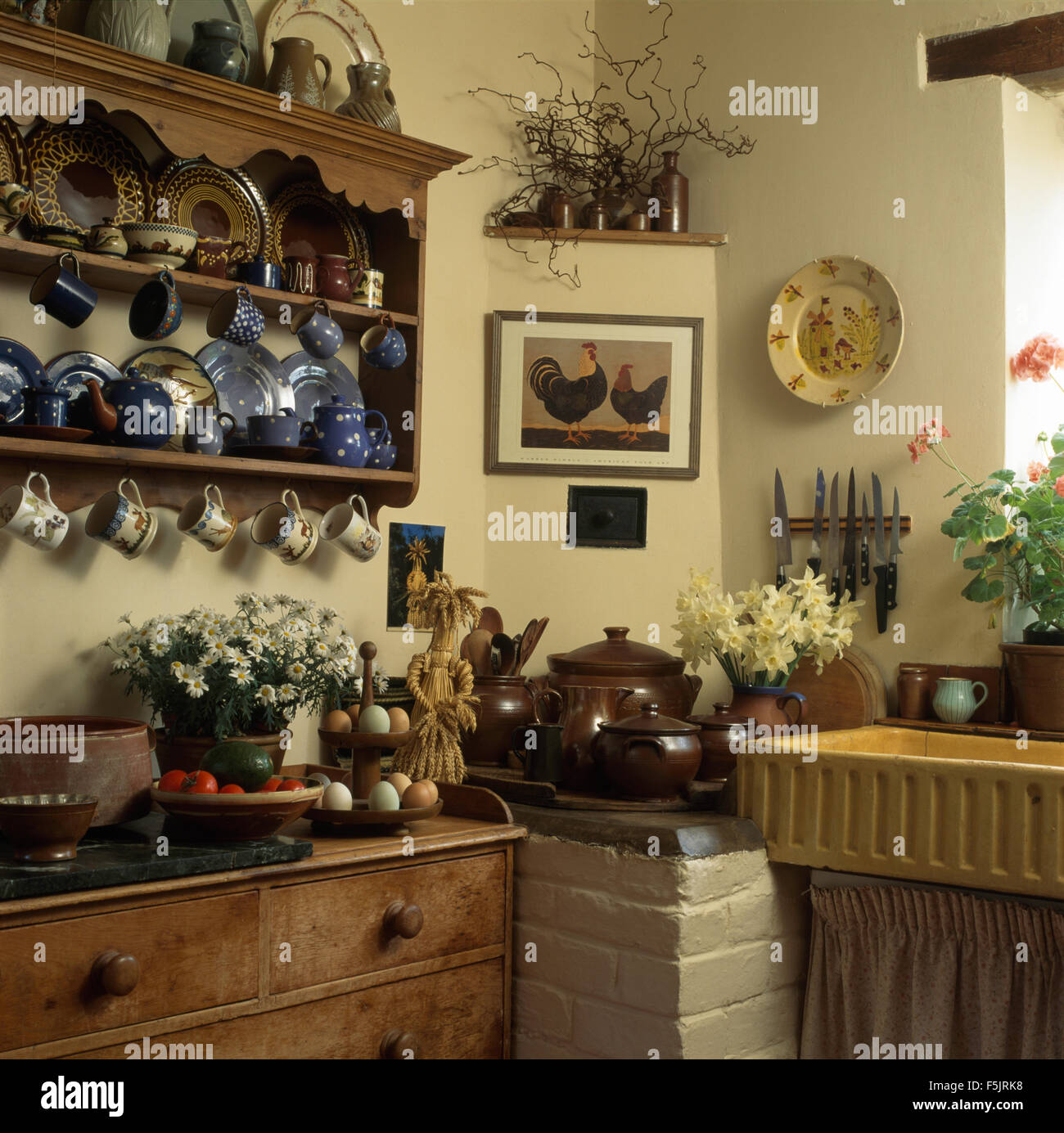 Collection of earthenware casserole dishes and blue pottery in cottage ...