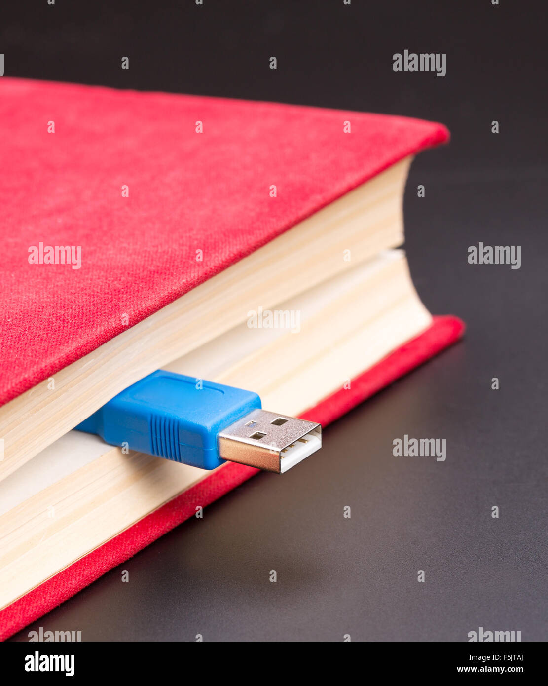 Blue usb cable sticks out from red book, closeup Stock Photo - Alamy