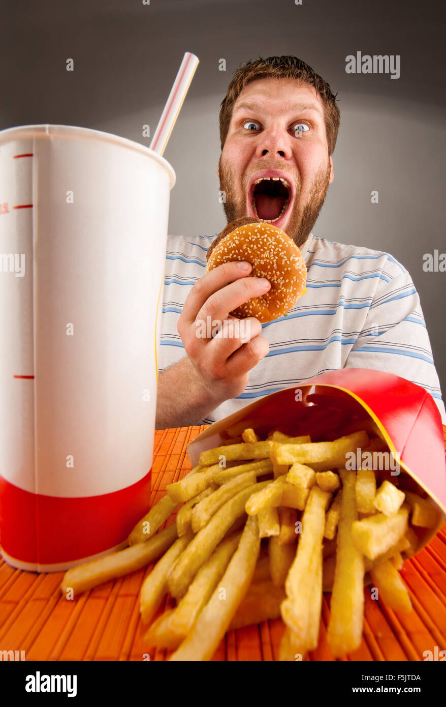 Portrait of expressive man eating fast food Stock Photo - Alamy