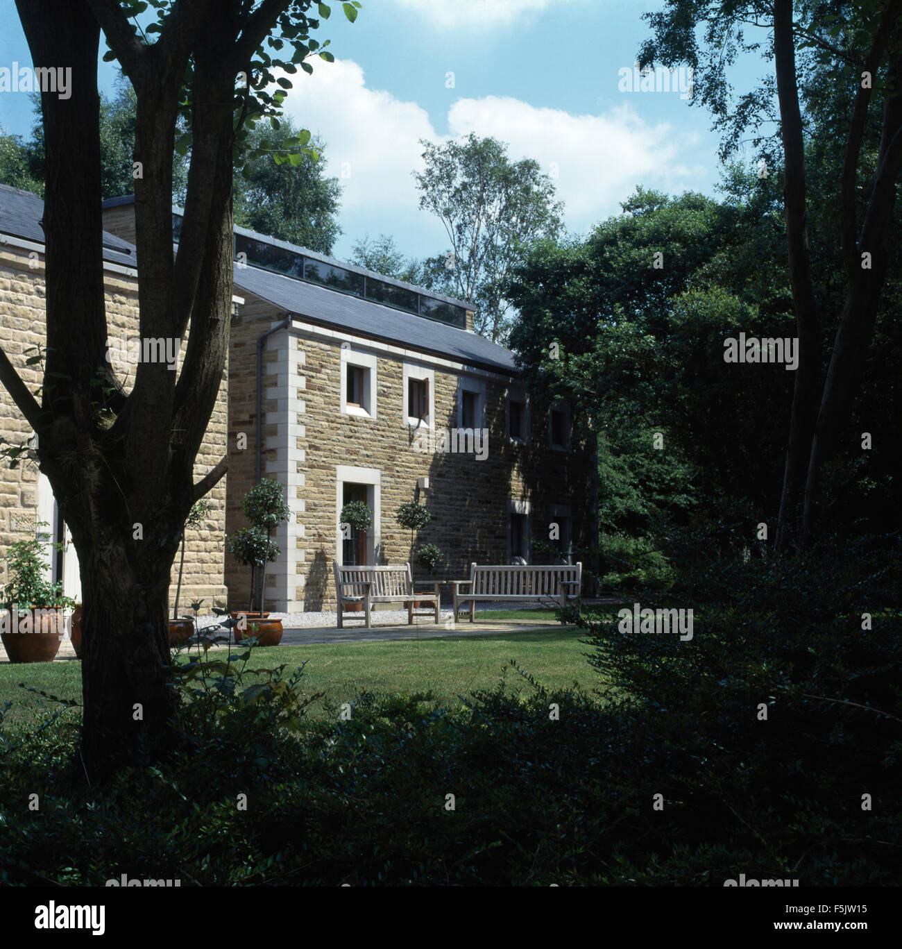 Exterior of a traditional stone country house with wooden benches on ...