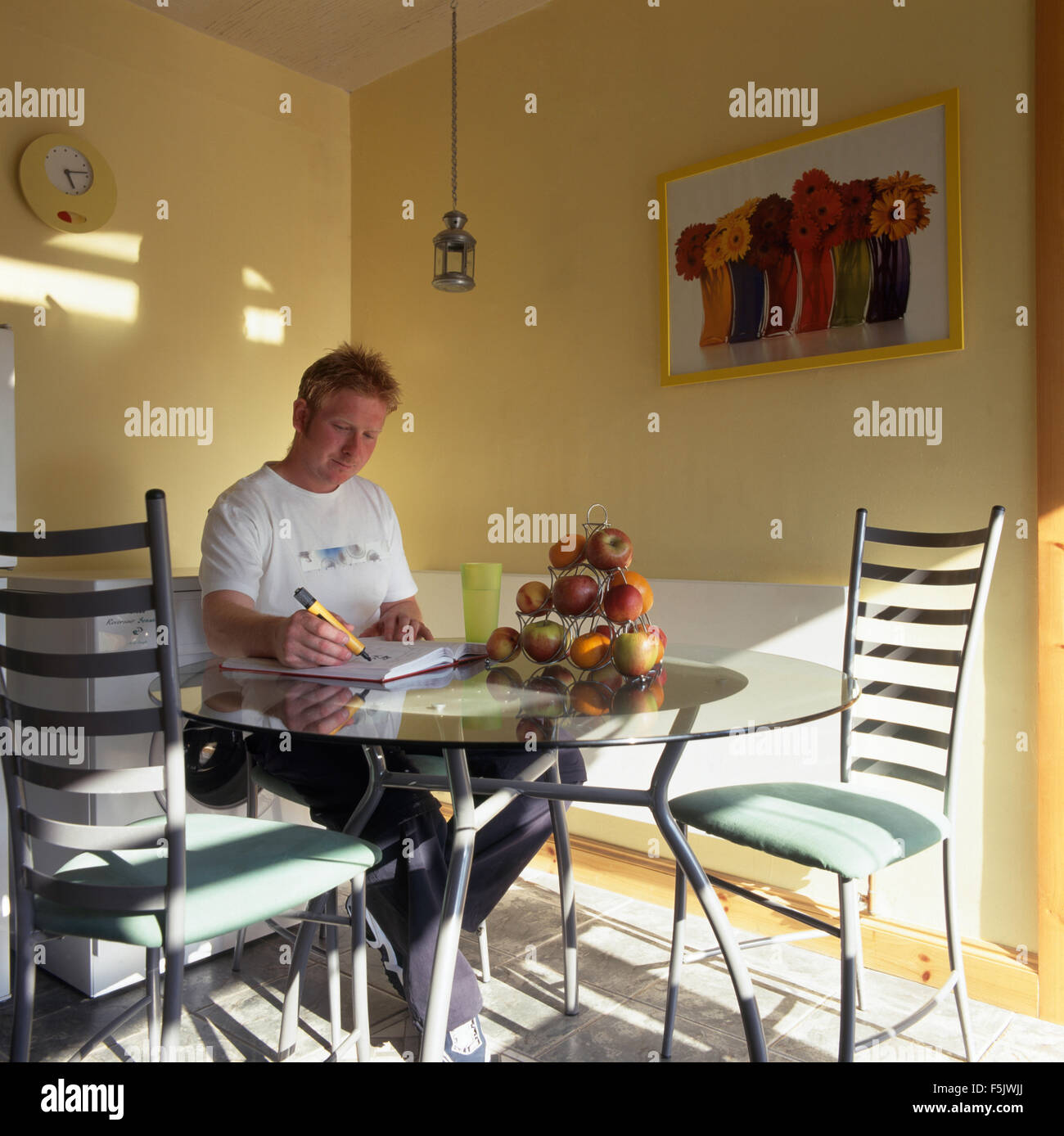 Man writing at a glass dining table FOR EDITORIAL USE ONLY Stock Photo ...