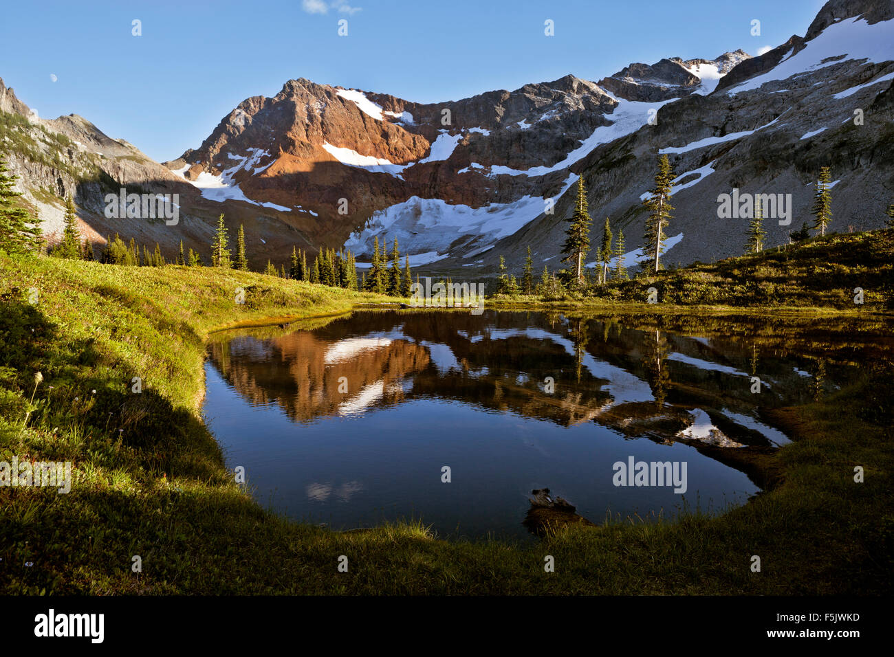 WASHINGTON - Red Mountain reflecting in a small tarn in the Upper Lyman ...