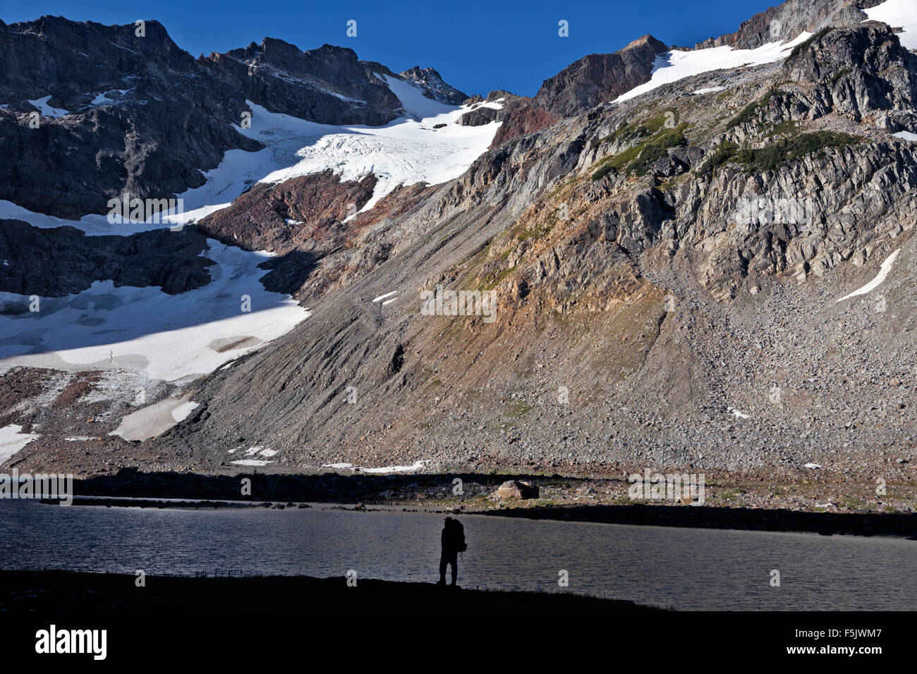 WASHINGTON - Backpacker at Upper Lyman Lake below the Lyman Glacier and ...