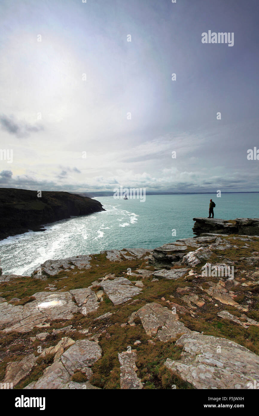 Adult male walker, Rugged shoreline, Port Isaac Bay near Tintagel town ...
