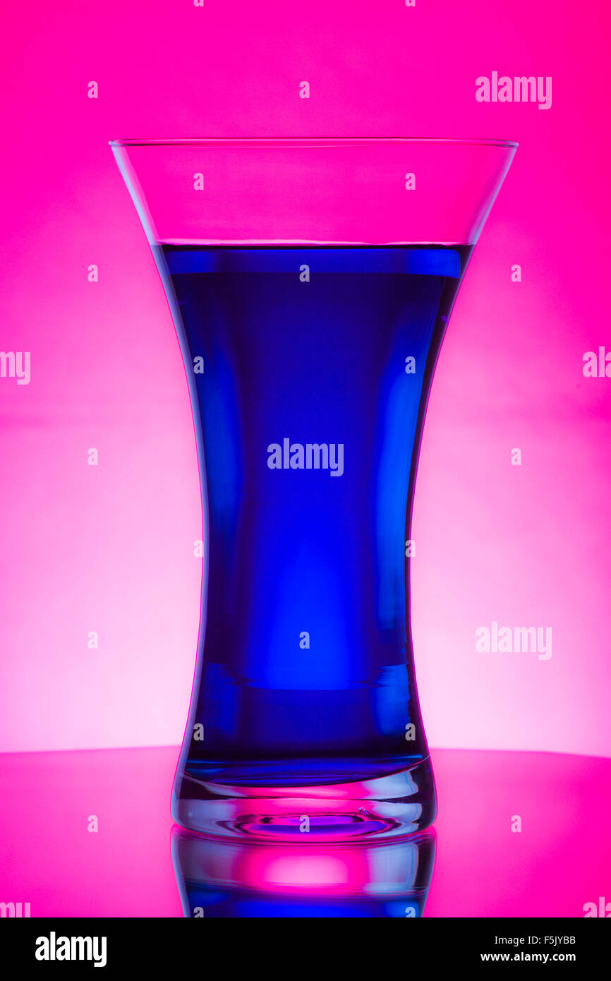 1 glass containing coloured liquid against a coloured background Stock ...