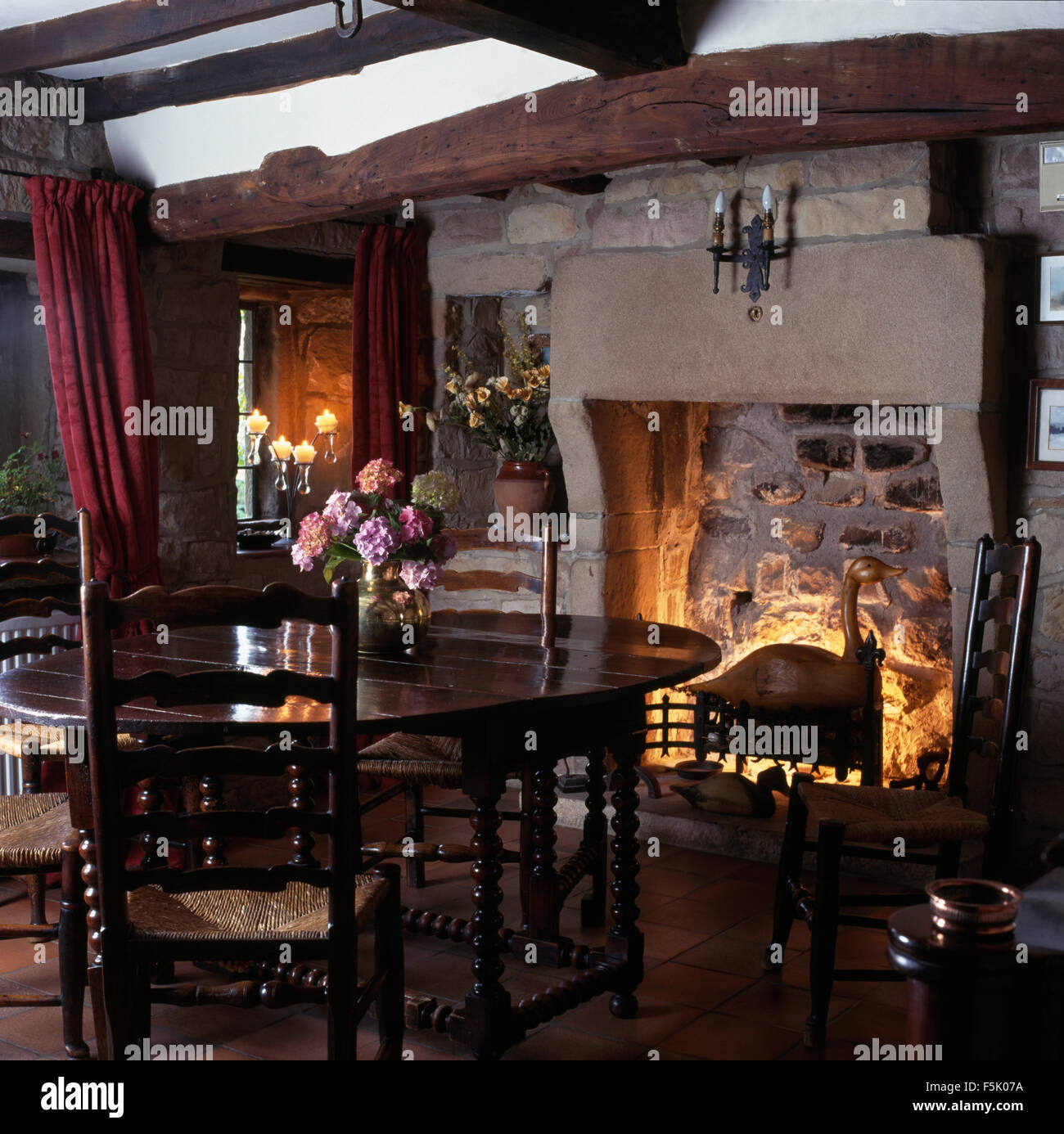 Antique oak table and rush seated chairs in cottage dining room with ...