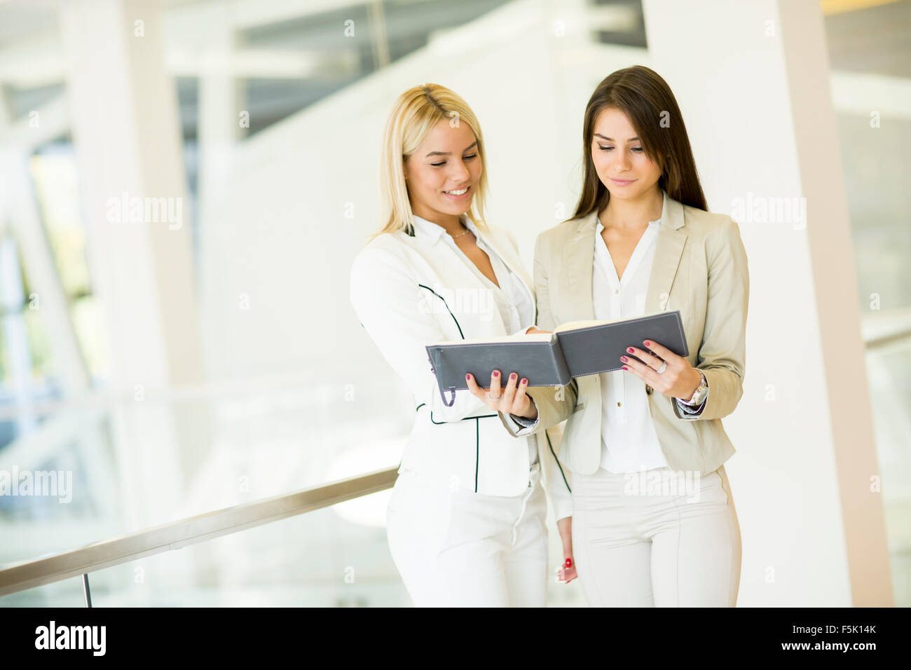 Young women looking at document in the office Stock Photo - Alamy
