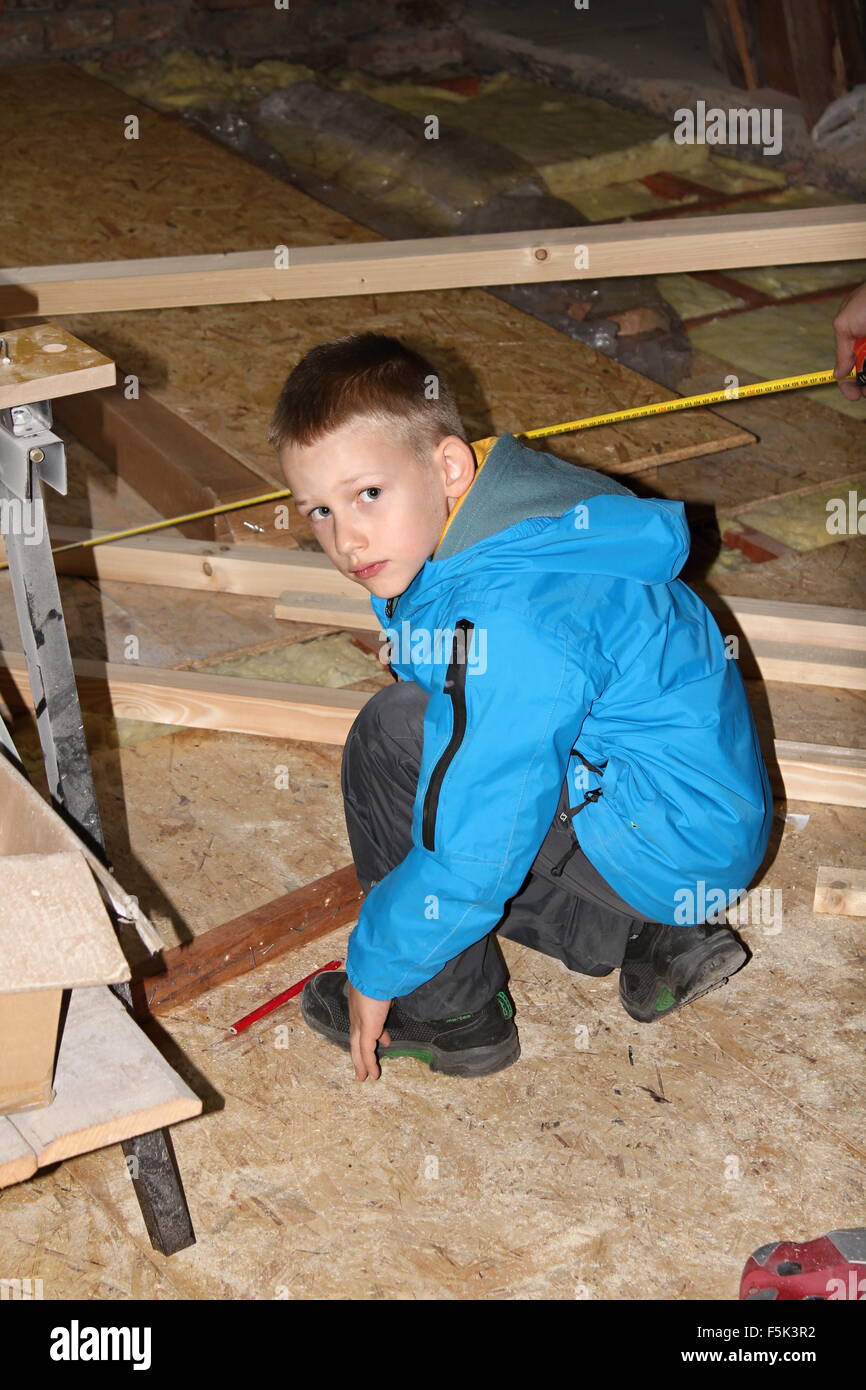 Handy little boy helps in building attic Stock Photo - Alamy