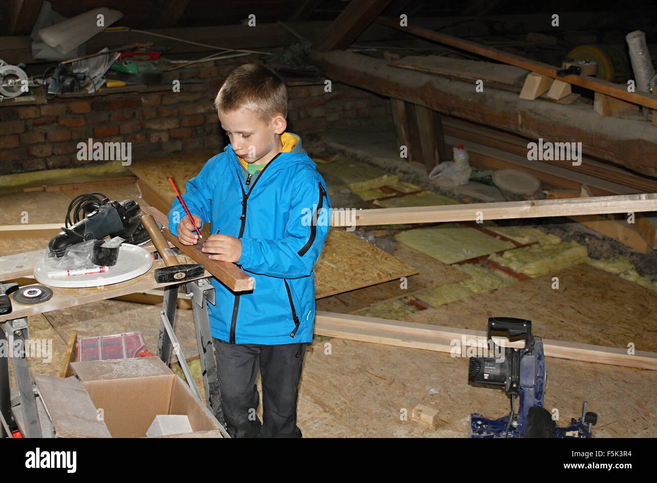 Handy little boy helps in building attic Stock Photo - Alamy