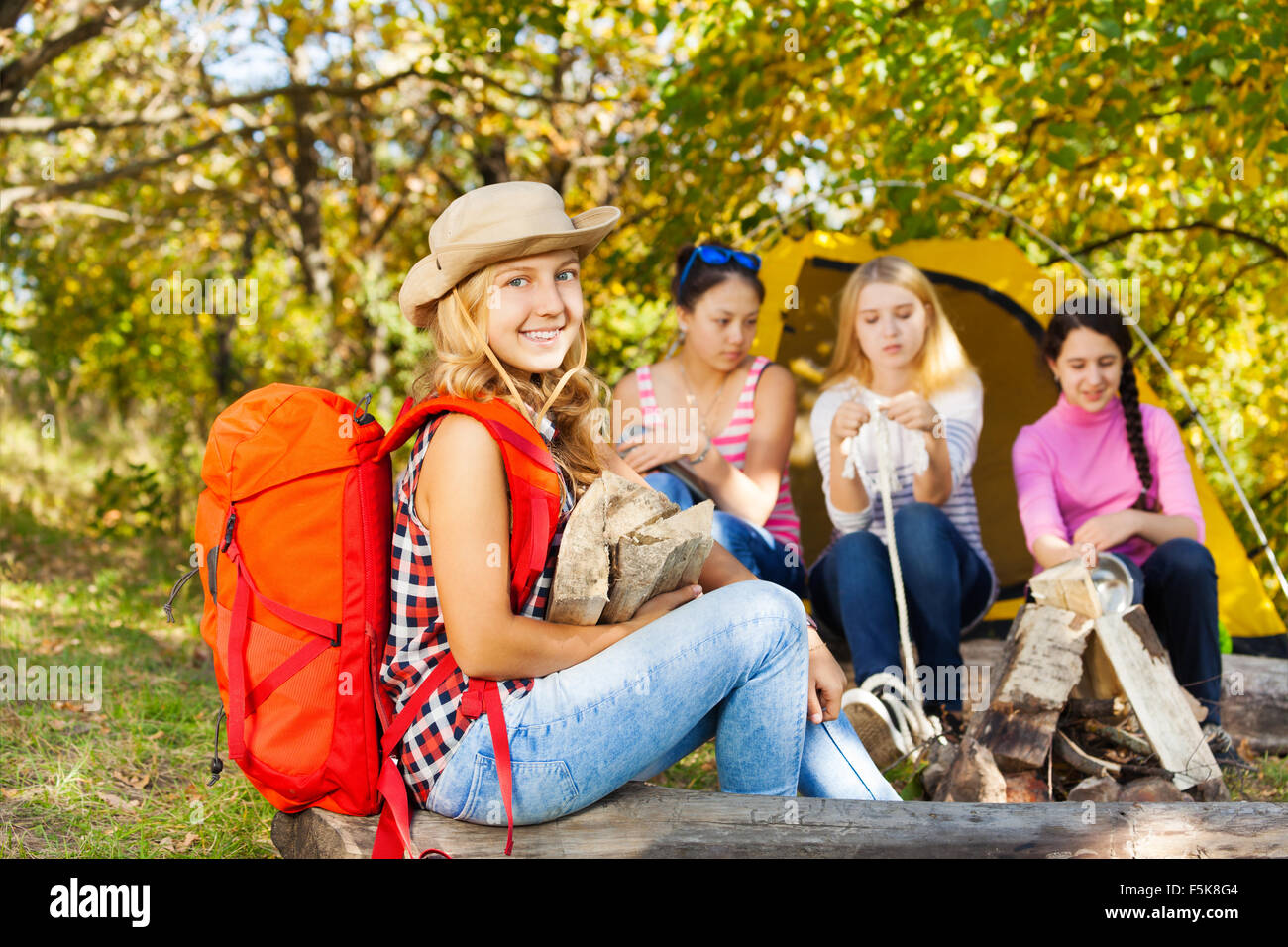 Happy beautiful girl with red rucksack sitting Stock Photo - Alamy