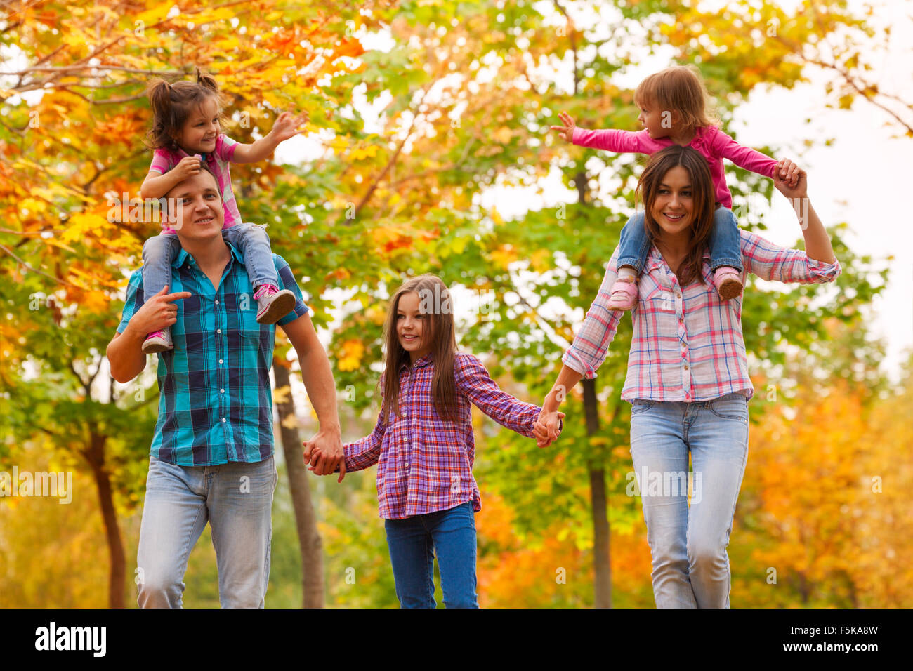 Mom walk with kids in the autumn maple forest Stock Photo - Alamy