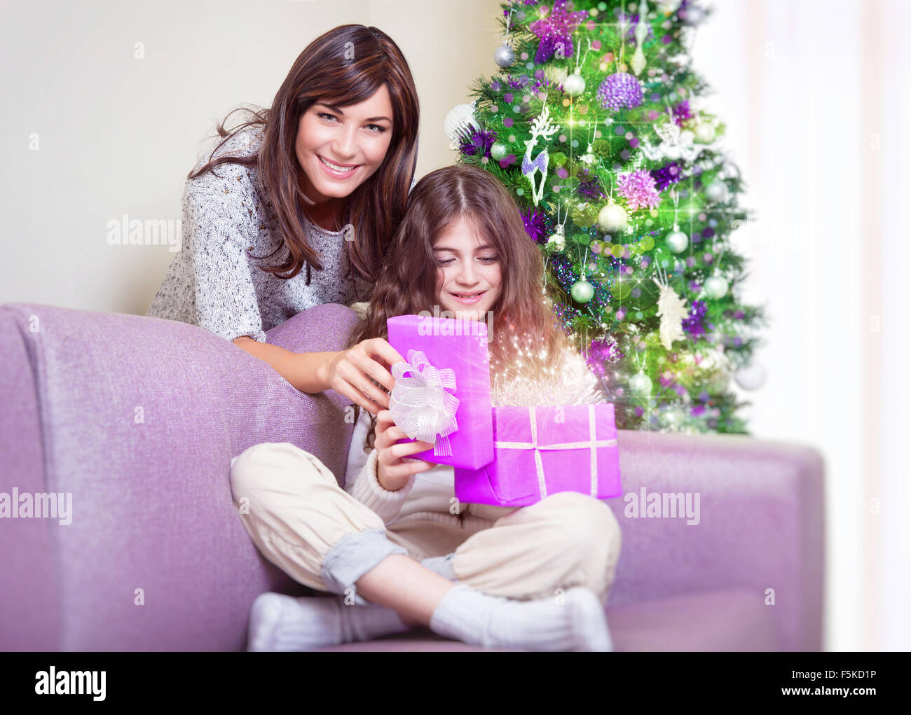 Cute teen girl receive gift from her beautiful young mother, happy ...