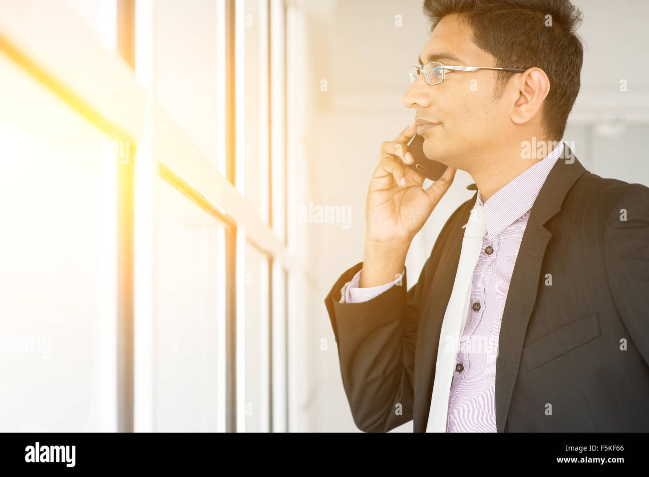 Indian estate agent checking on new office to let and calling on phone ...