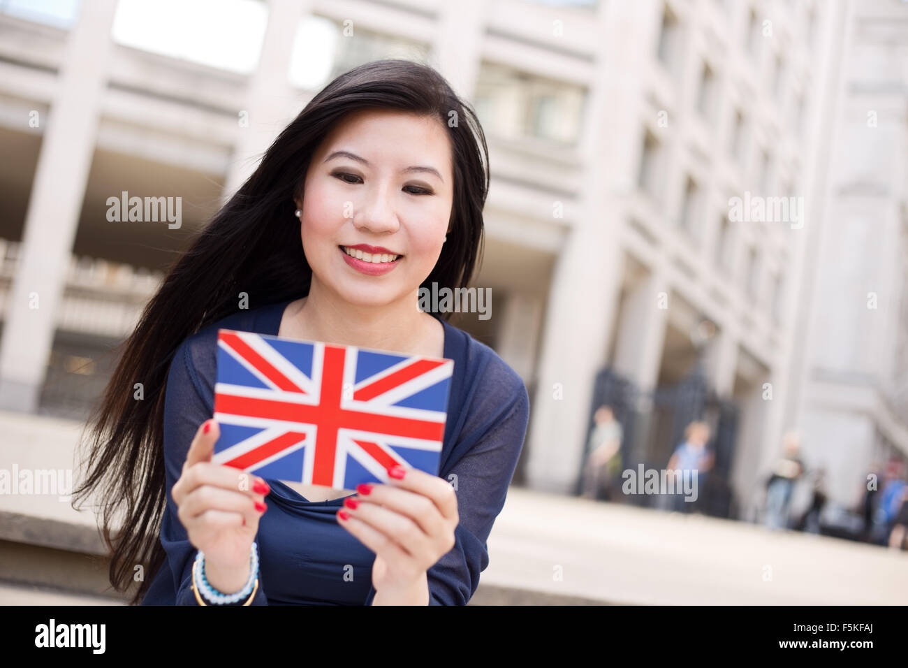 Japanese woman reading a post card with the union jack Stock Photo - Alamy