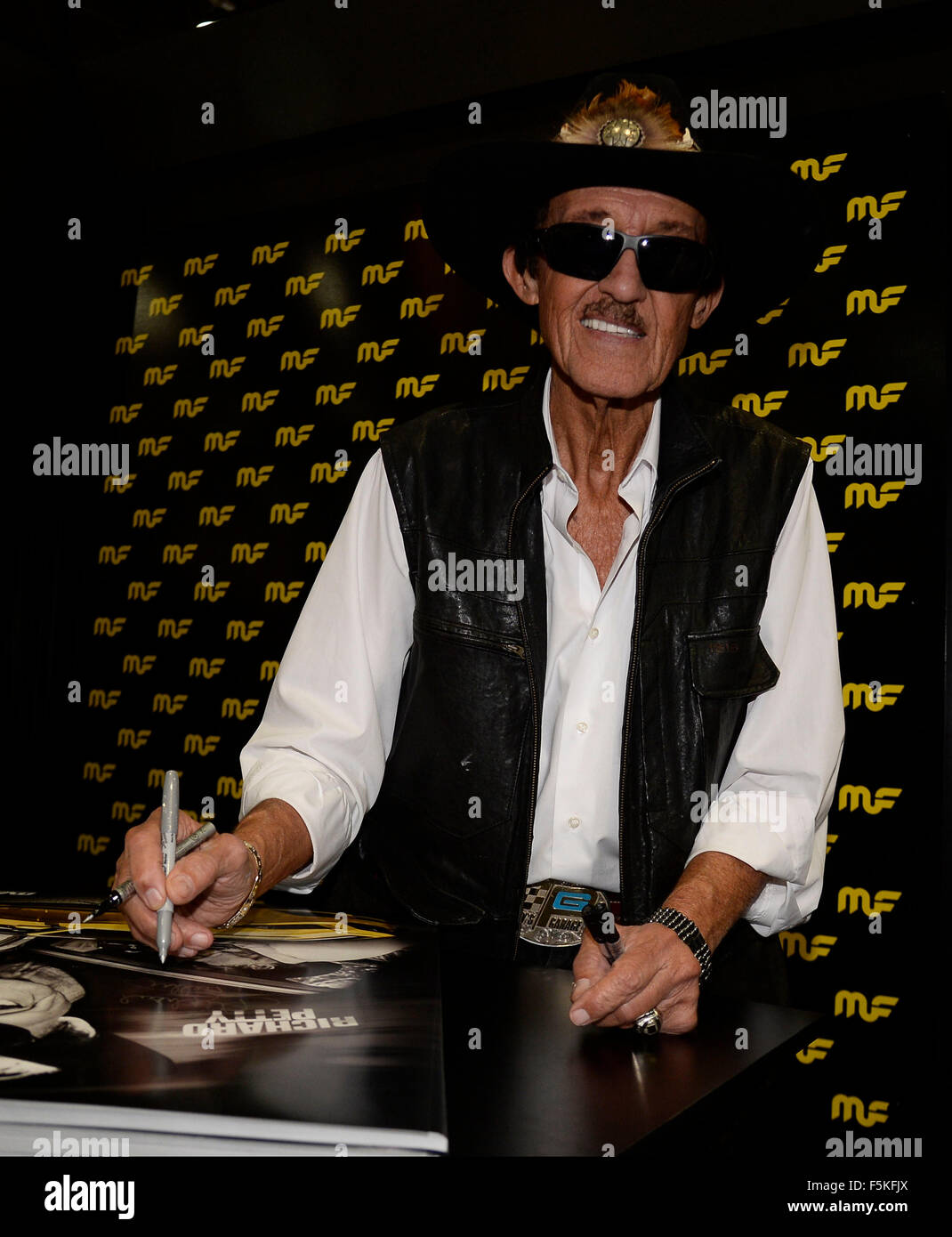 Former NASCAR champion driver Richard Petty signs autographs for fans ...