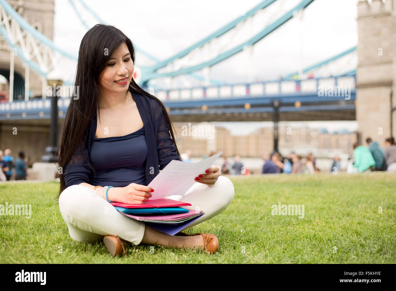 Japanese student doing her paperwork by tower bridge Stock Photo - Alamy