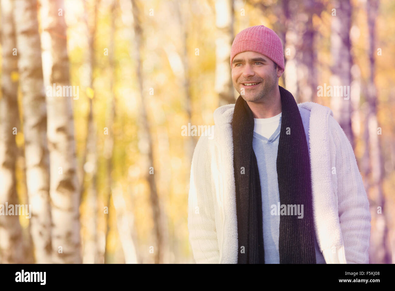 man standing between trees in fall and smiles Stock Photo - Alamy