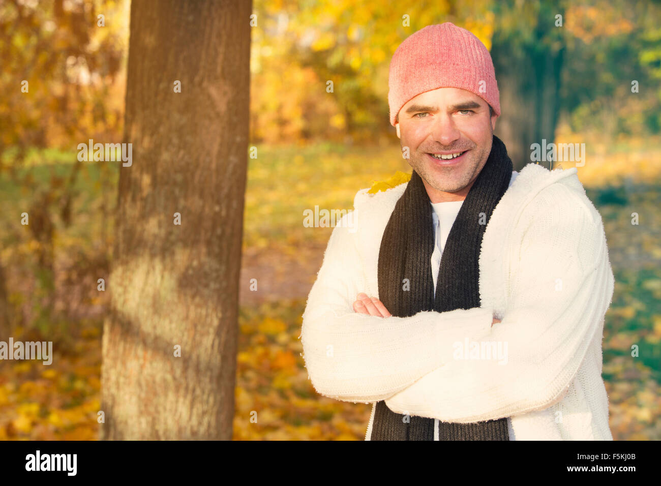 man standing by a tree in fall and smiles Stock Photo - Alamy
