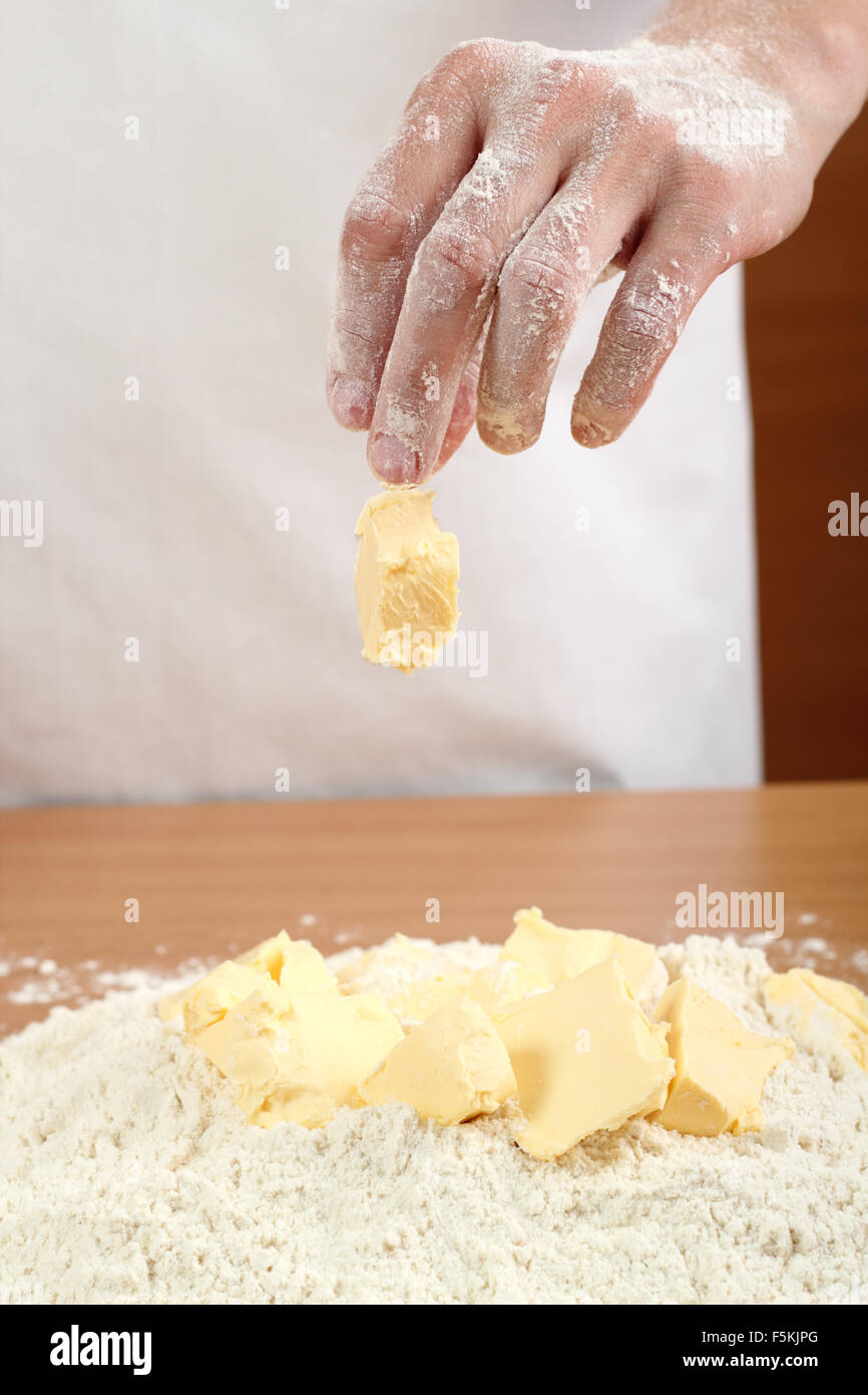 A baker adding butter to flour. Making Pastry Dough for Hungarian Cake ...