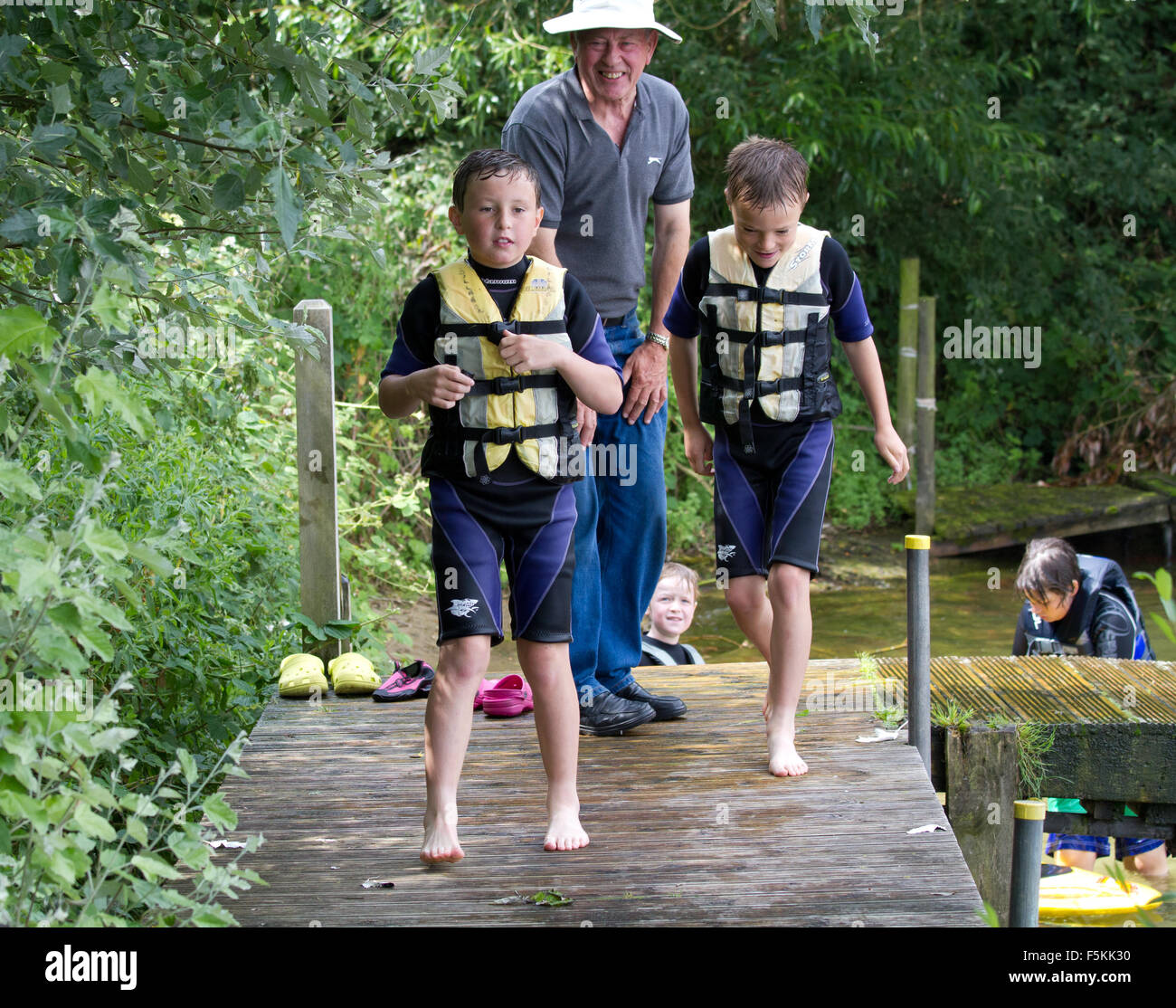 Children in life Jackets buoyancy aids wet suits Stock Photo - Alamy