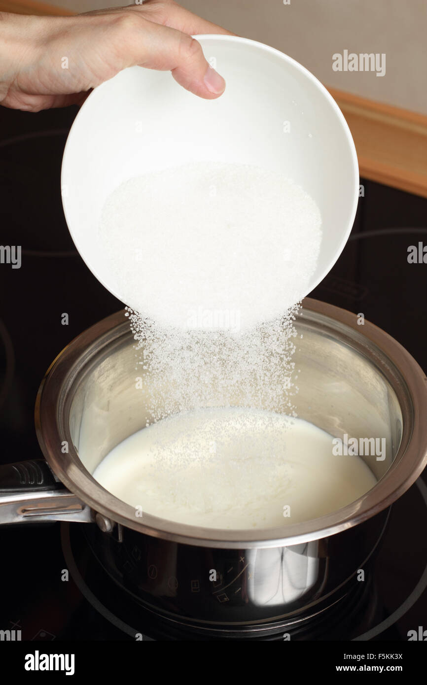 Pouring sugar into milk pot. Making Chocolate Cream. Series Stock Photo ...