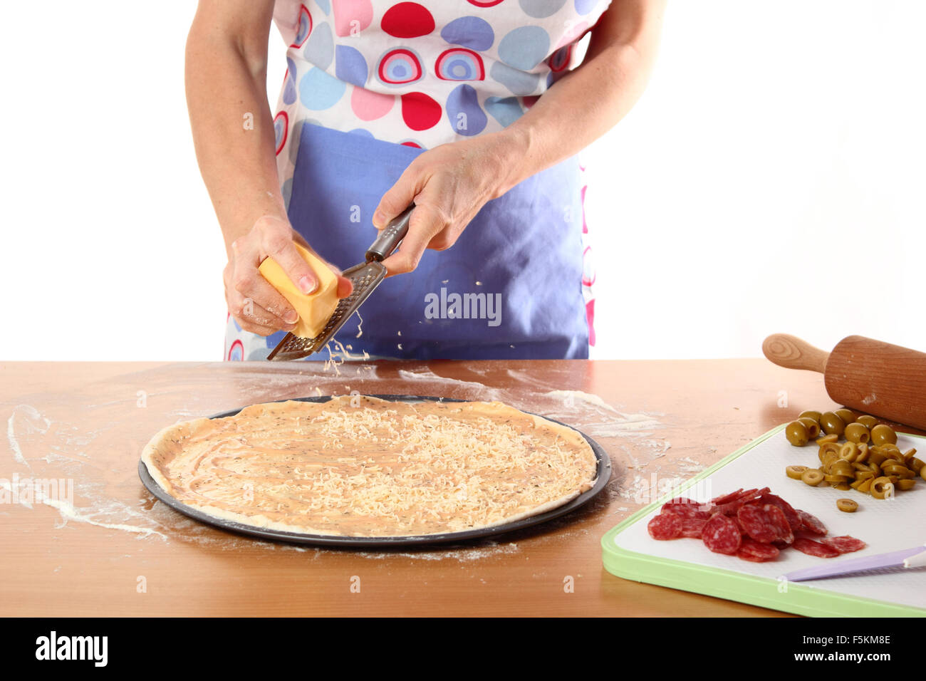 Grating cheese. Making Pizza with Salami, Olives and Cheese. Series ...